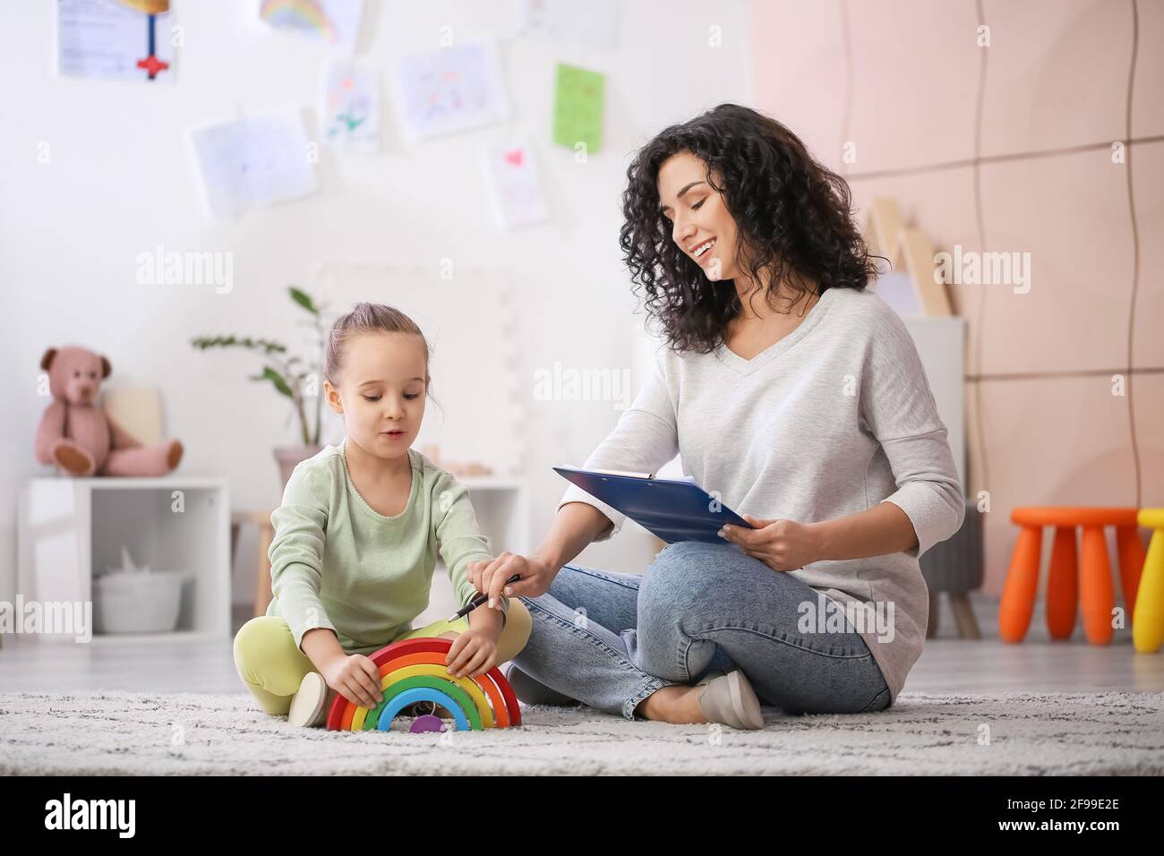 Female psychologist working with little girl at home Stock Photo - Alamy
