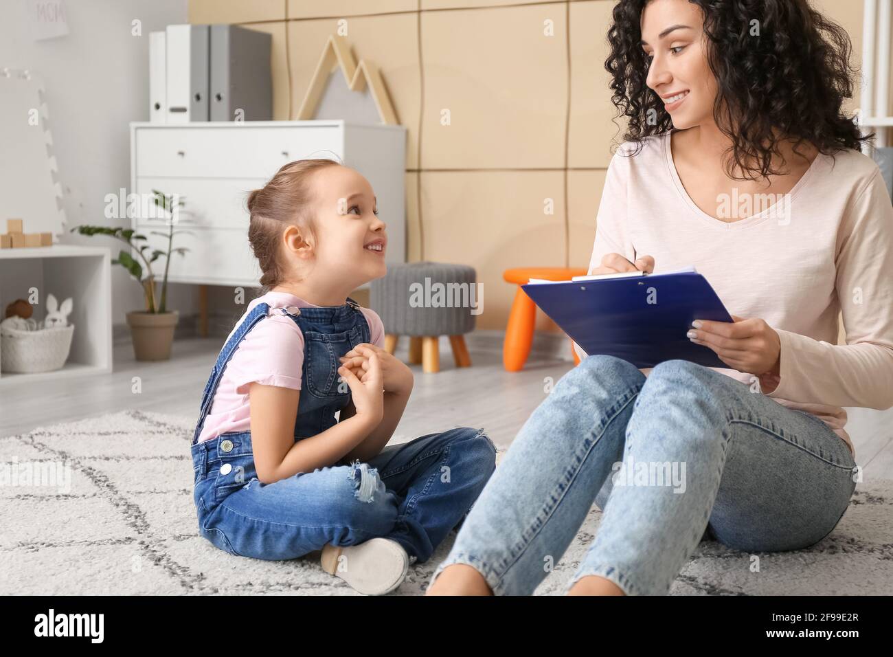 Female psychologist working with little girl at home Stock Photo - Alamy