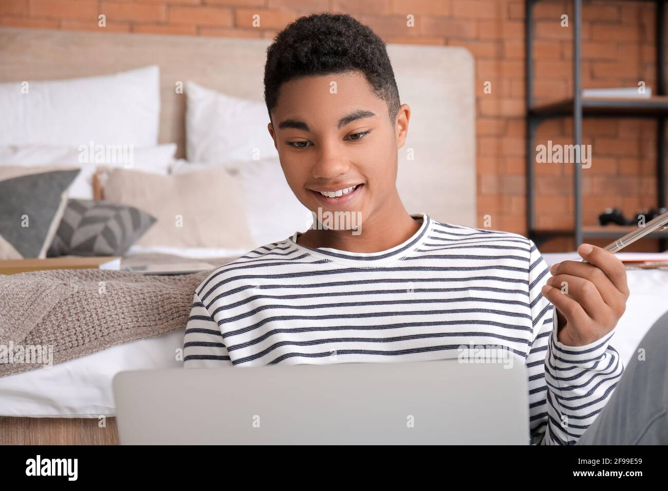 African-American student with laptop studying online at home Stock ...