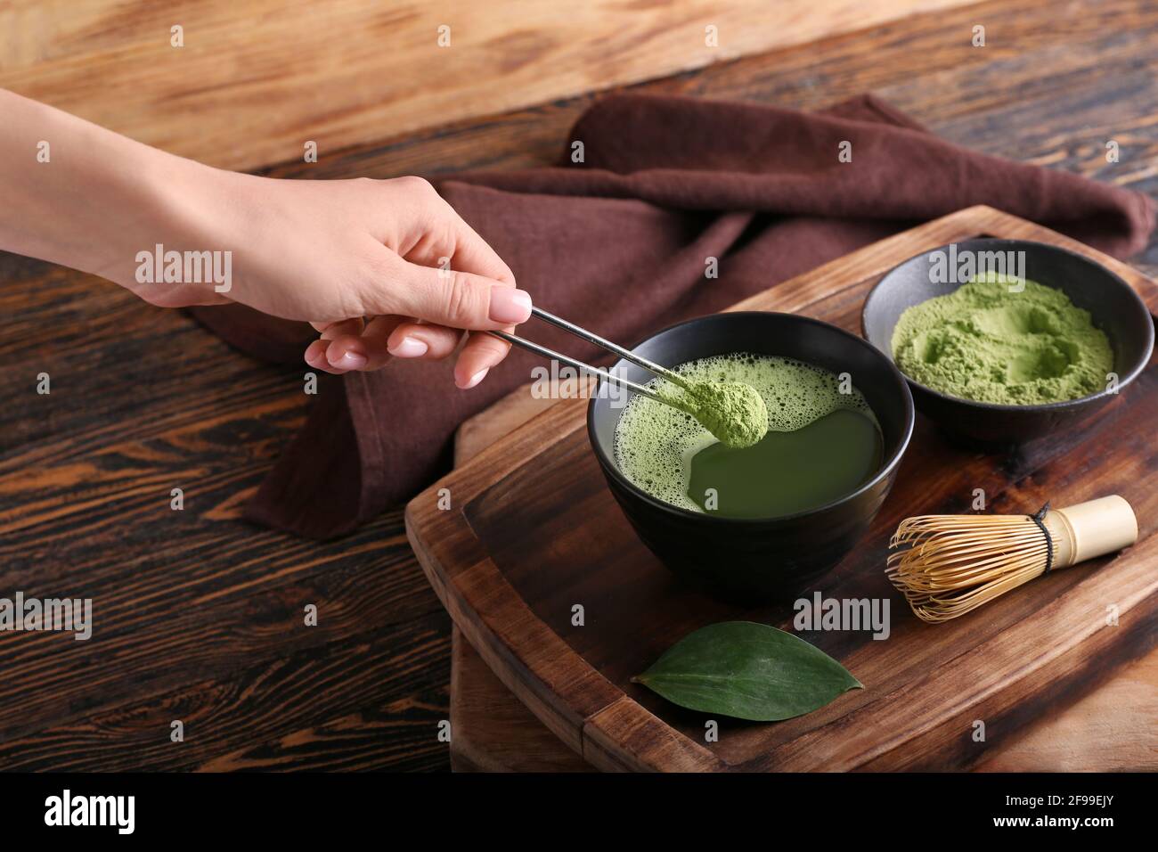 Woman preparing matcha tea on wooden background Stock Photo - Alamy