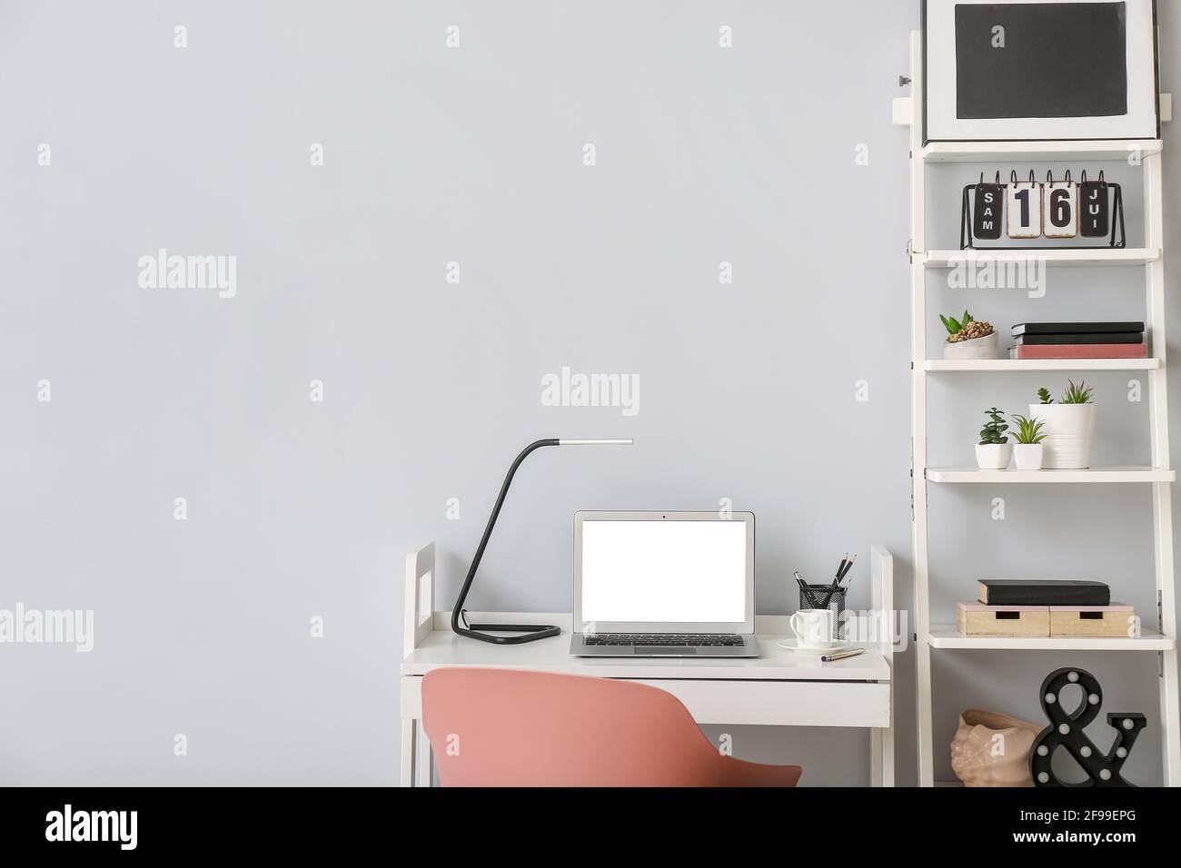 Comfortable workplace with laptop near light wall in room Stock Photo ...