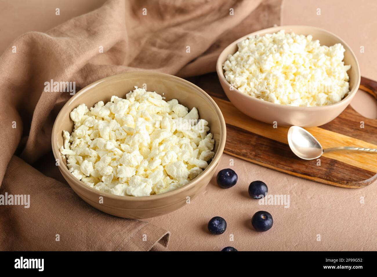 Bowls of cottage cheese on color background Stock Photo - Alamy