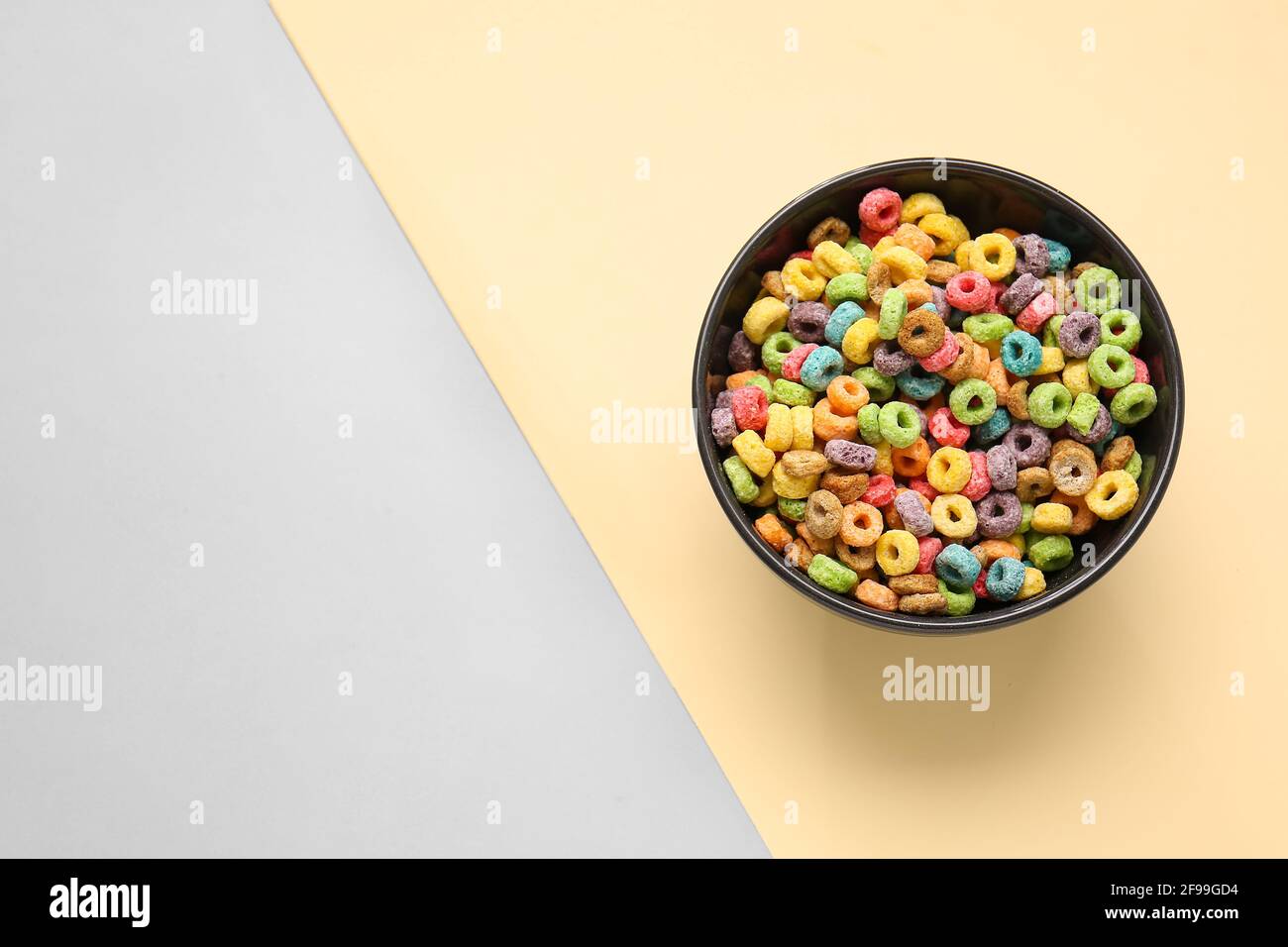Bowl with cereal rings on color background Stock Photo - Alamy
