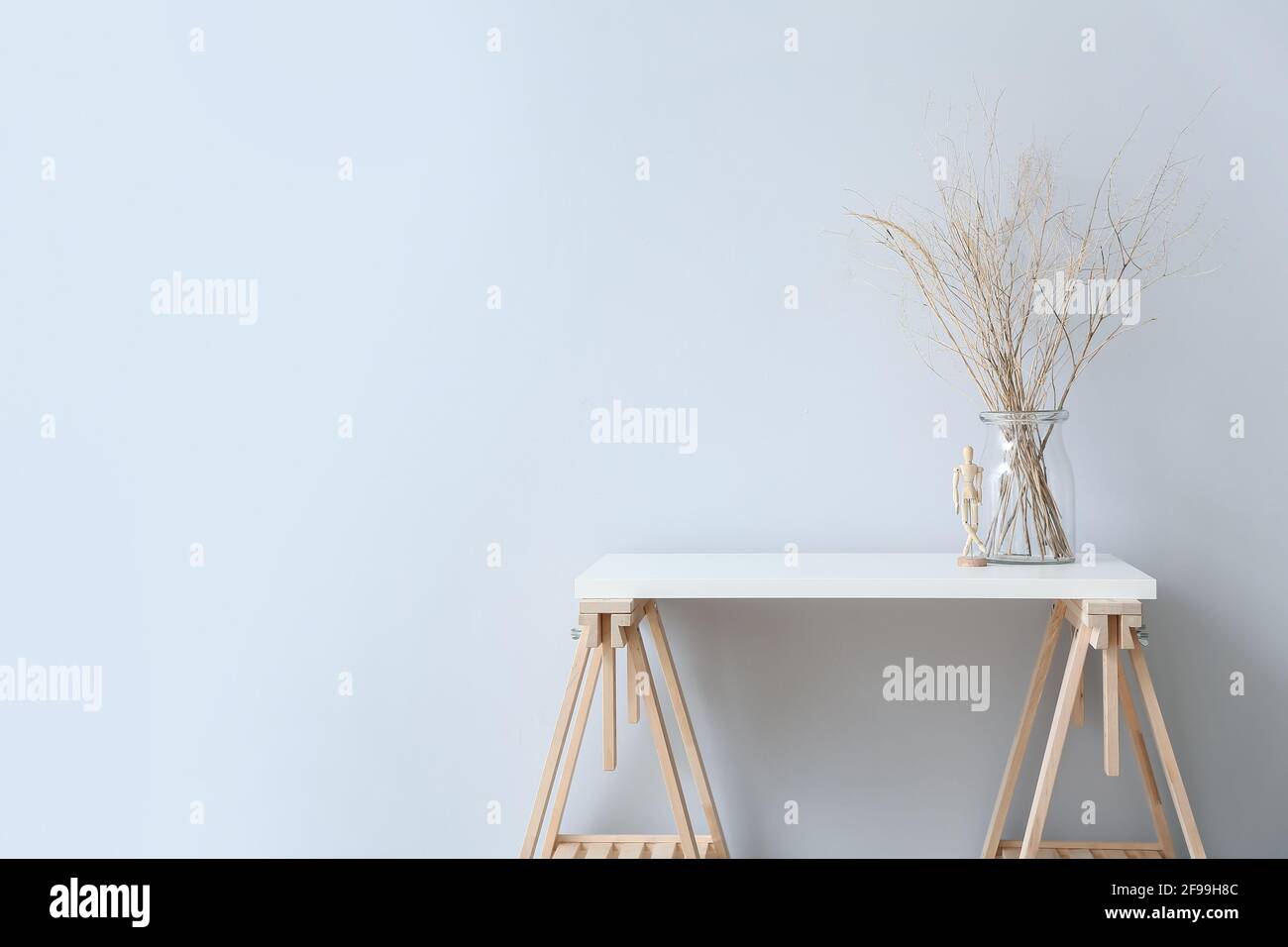 Modern table with decor near light wall Stock Photo - Alamy