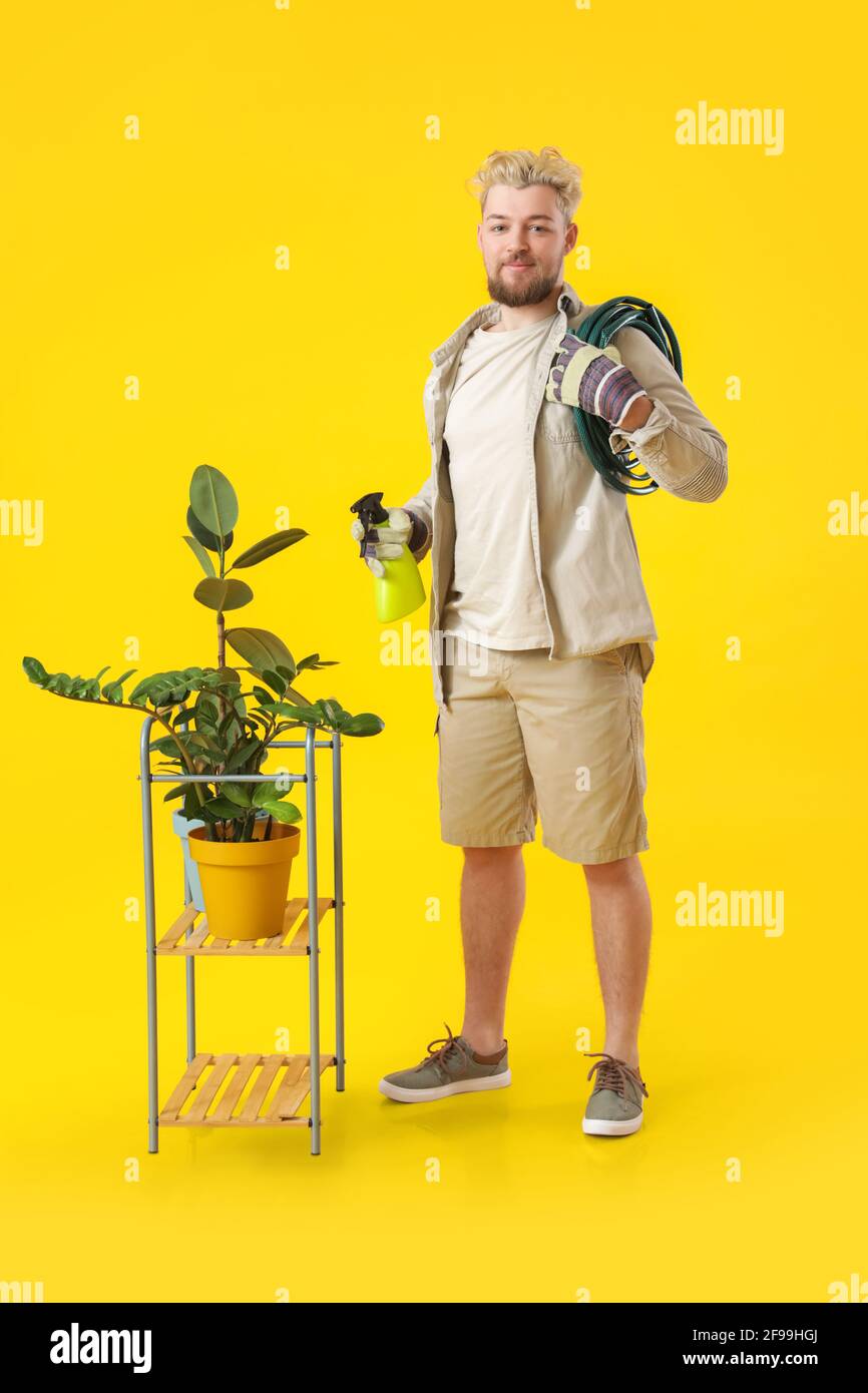 Young male gardener on color background Stock Photo - Alamy