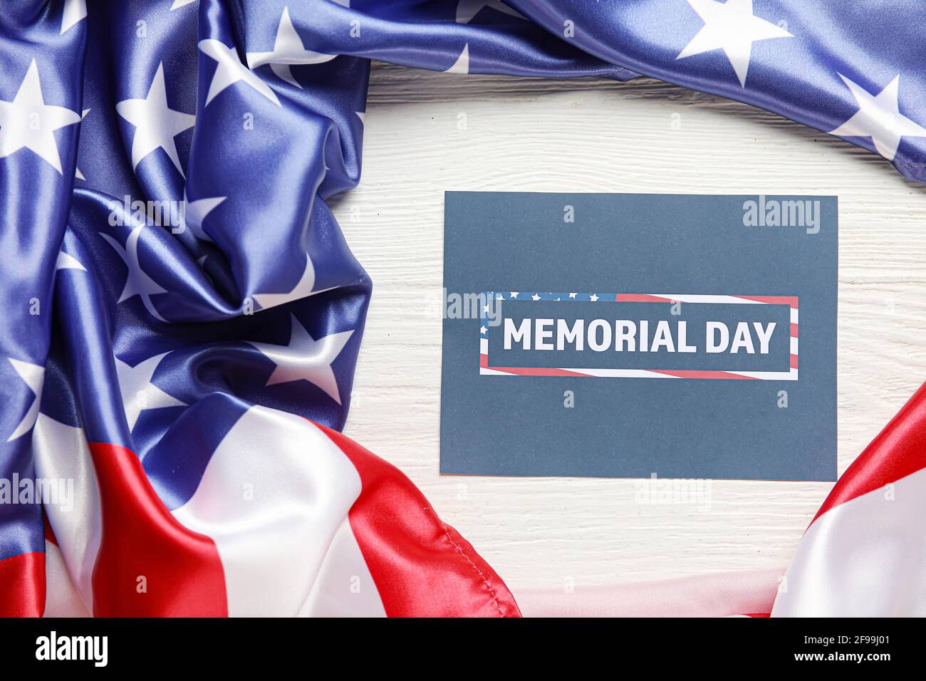 Paper sheet with text MEMORIAL DAY and USA flag on white wooden ...