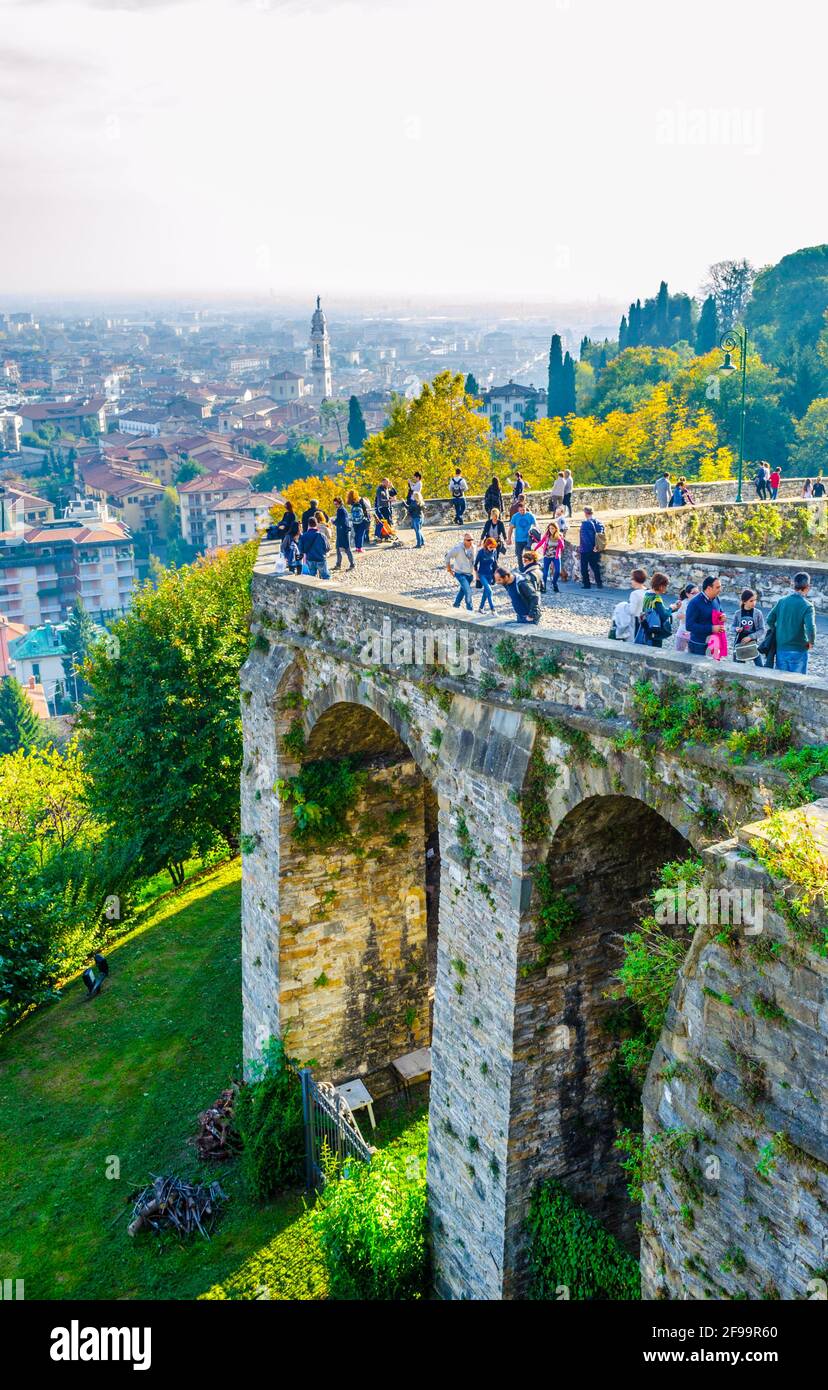 BERGAMO, ITALY, NOVEMBER 2, 2014: People are walking on a stone bridge ...