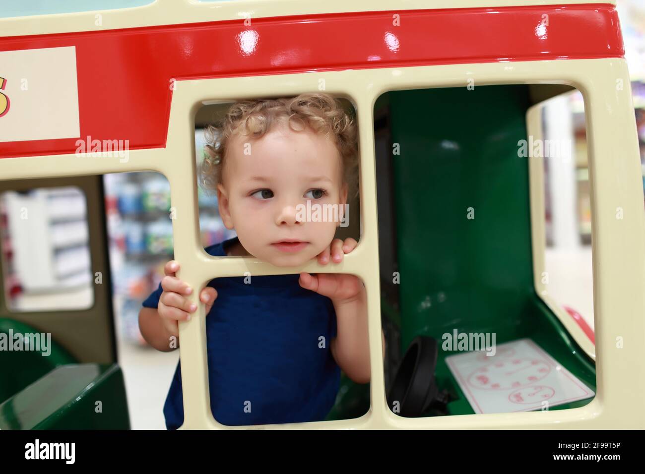Toddler is in a little bus at playground Stock Photo - Alamy
