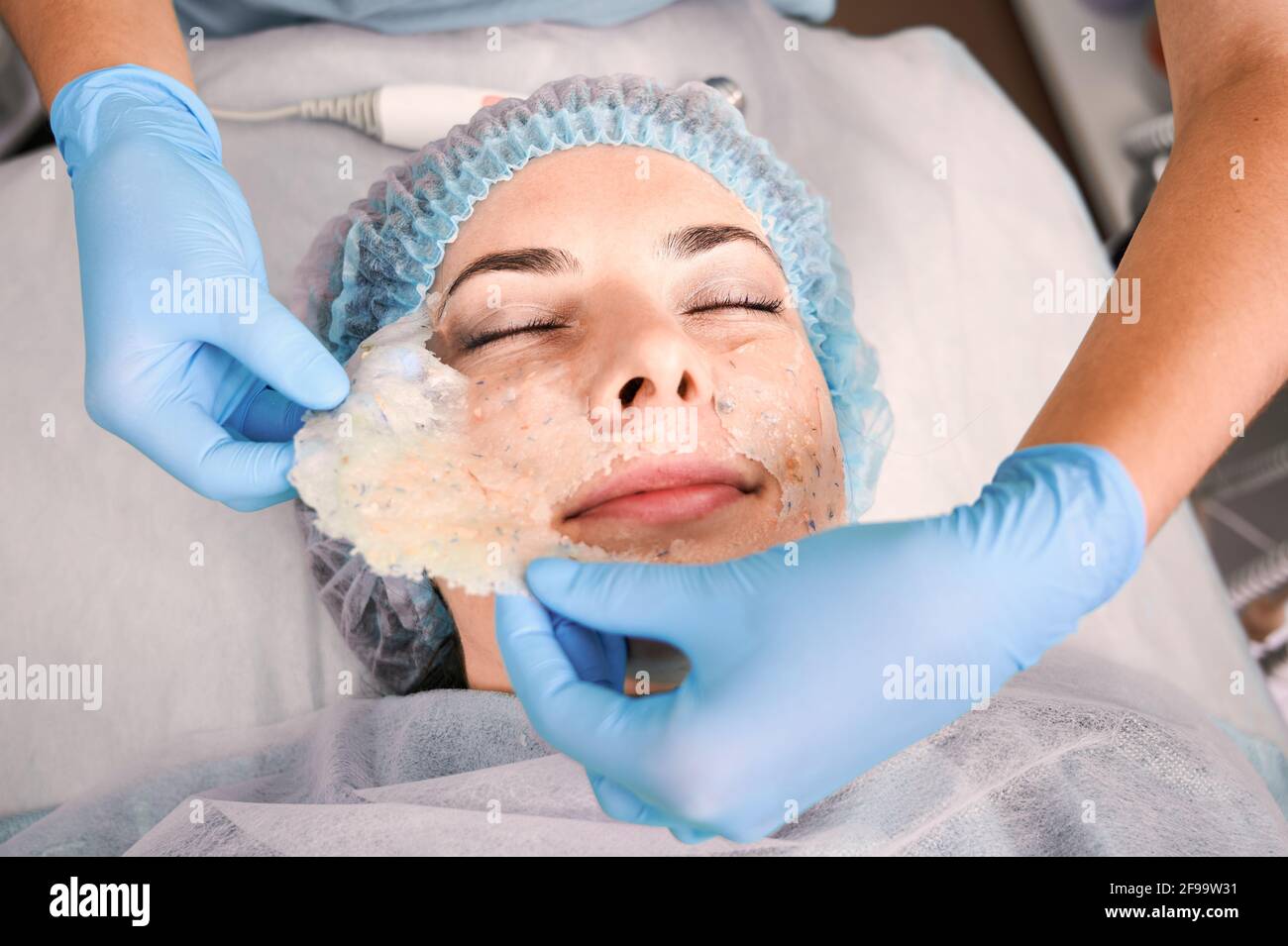 Close up of beautician hands pulling off deep cleansing mask from ...
