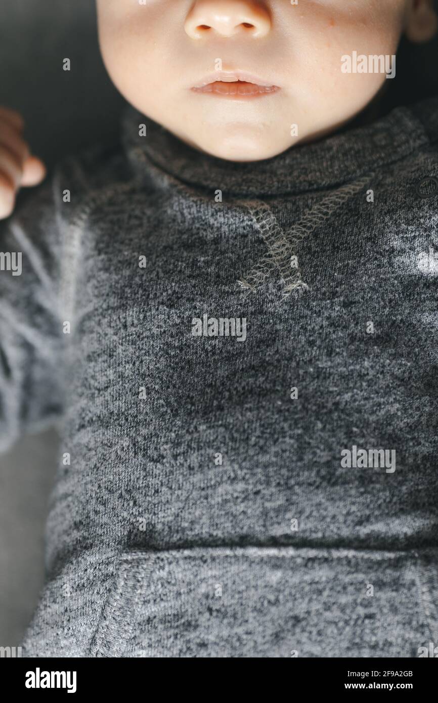 Cropped photo of newborn baby sleeping on gray background in gray ...