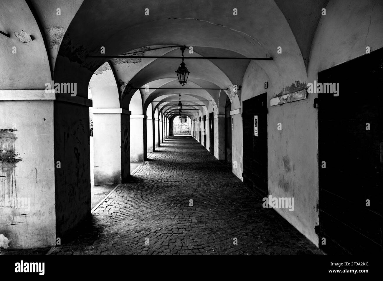 Grayscale of a beautiful arched corridor with columns Stock Photo - Alamy