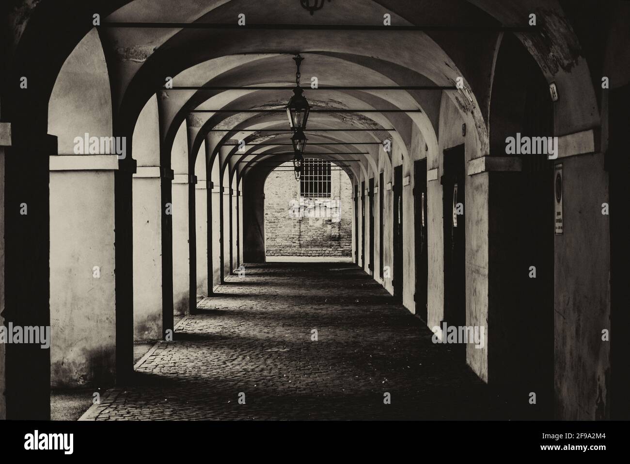 Grayscale of a beautiful arched corridor with columns Stock Photo - Alamy