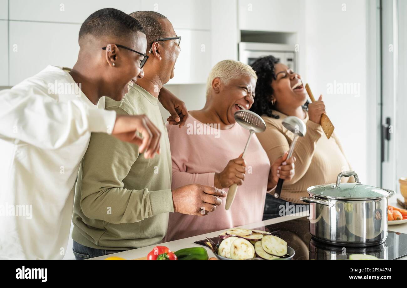 Happy black family having fun cooking together in modern kitchen - Food ...