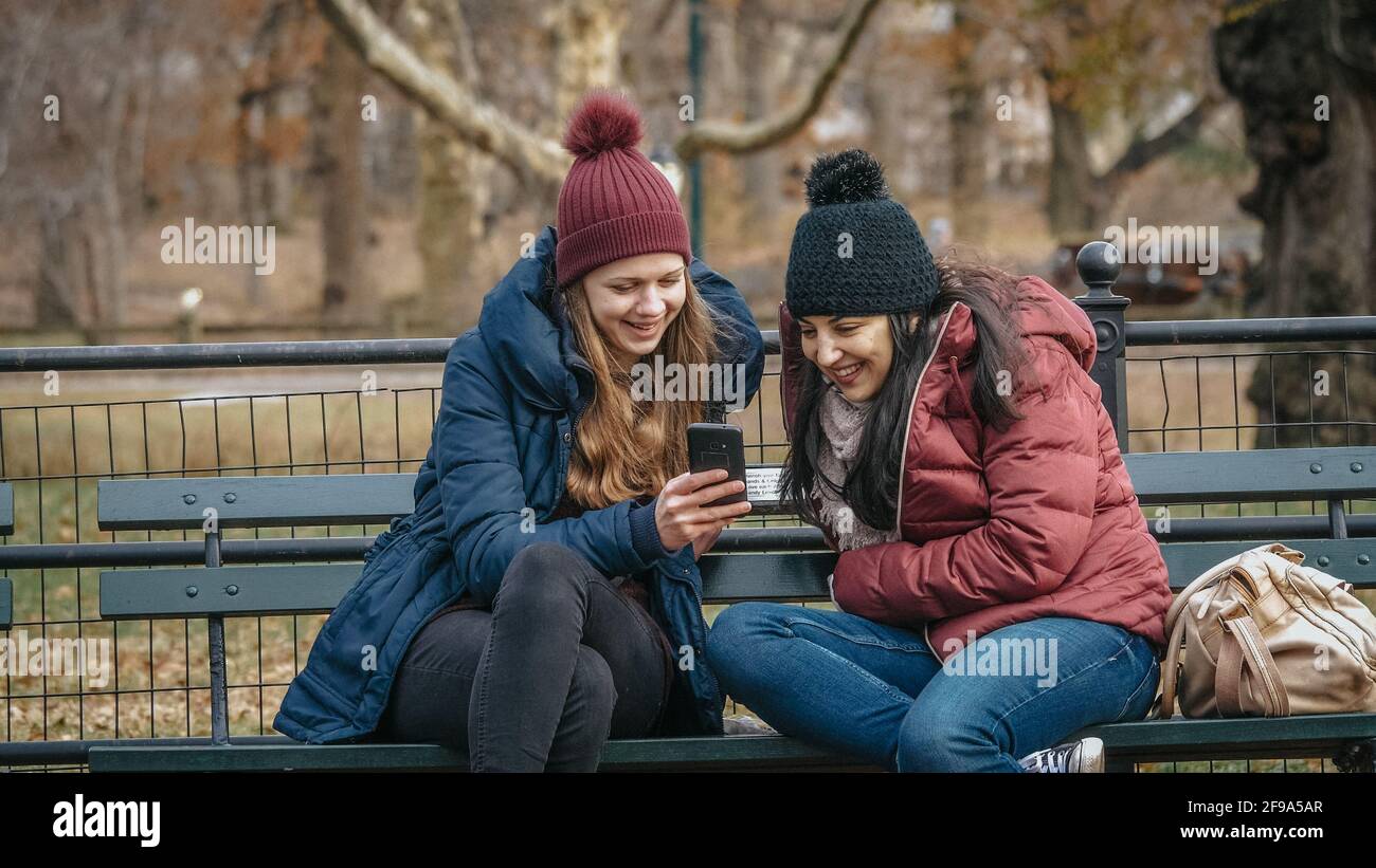 Two friends check the photos on their cell phone - travel photography ...
