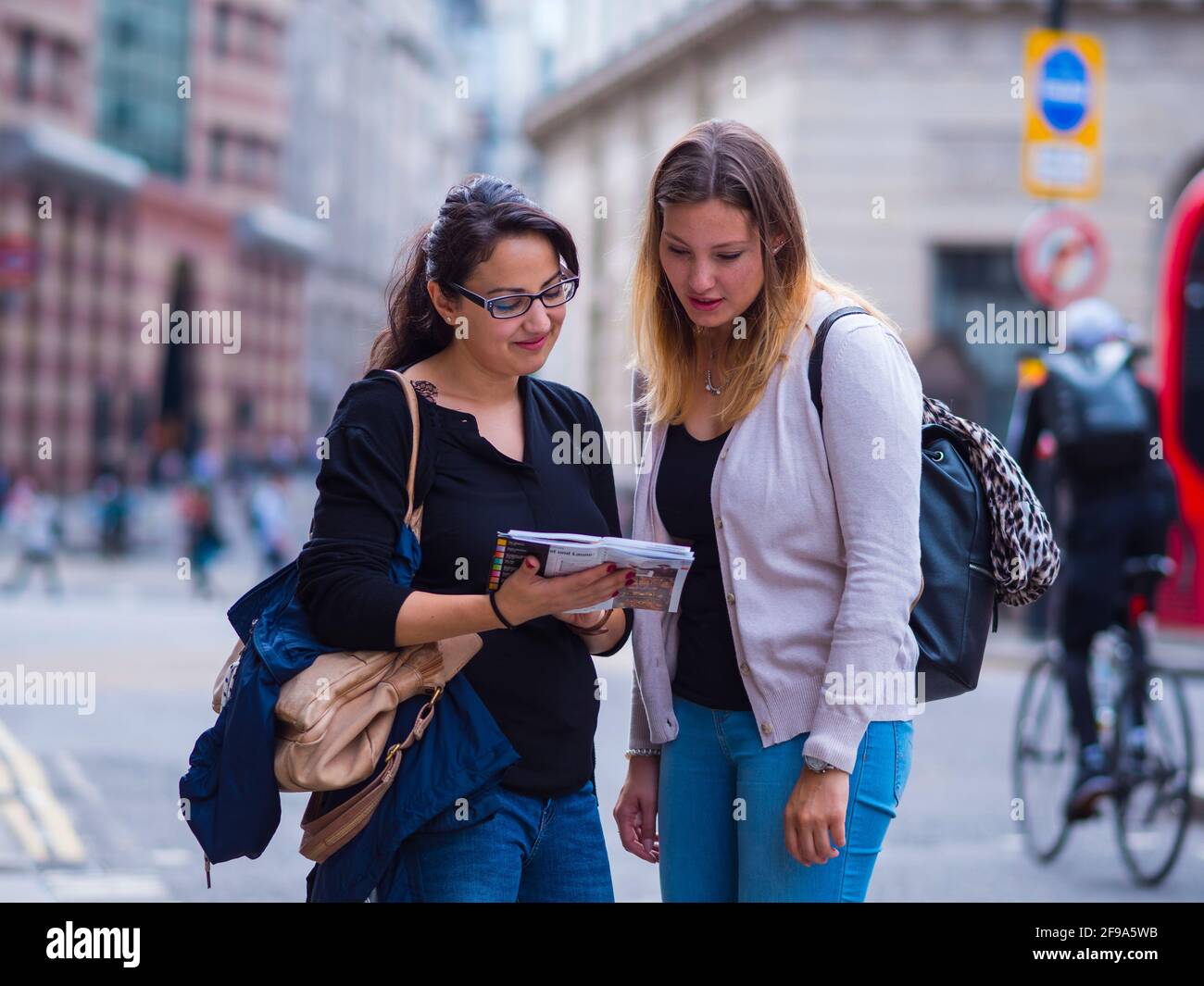 Two girls read a map in the city center of London - travel photography ...