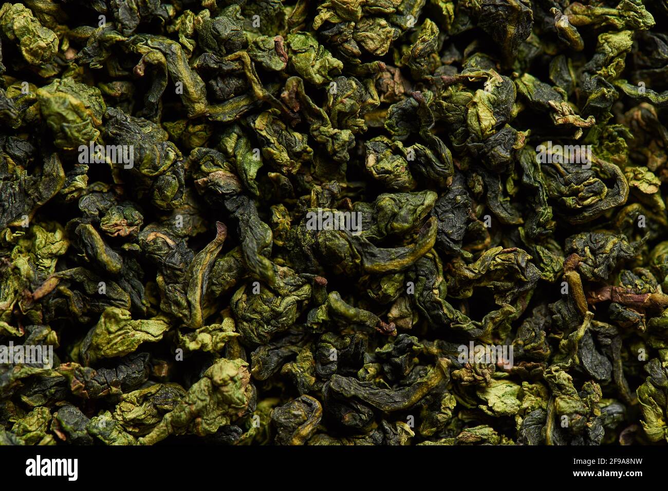Green tea leaves texture as a background Stock Photo - Alamy