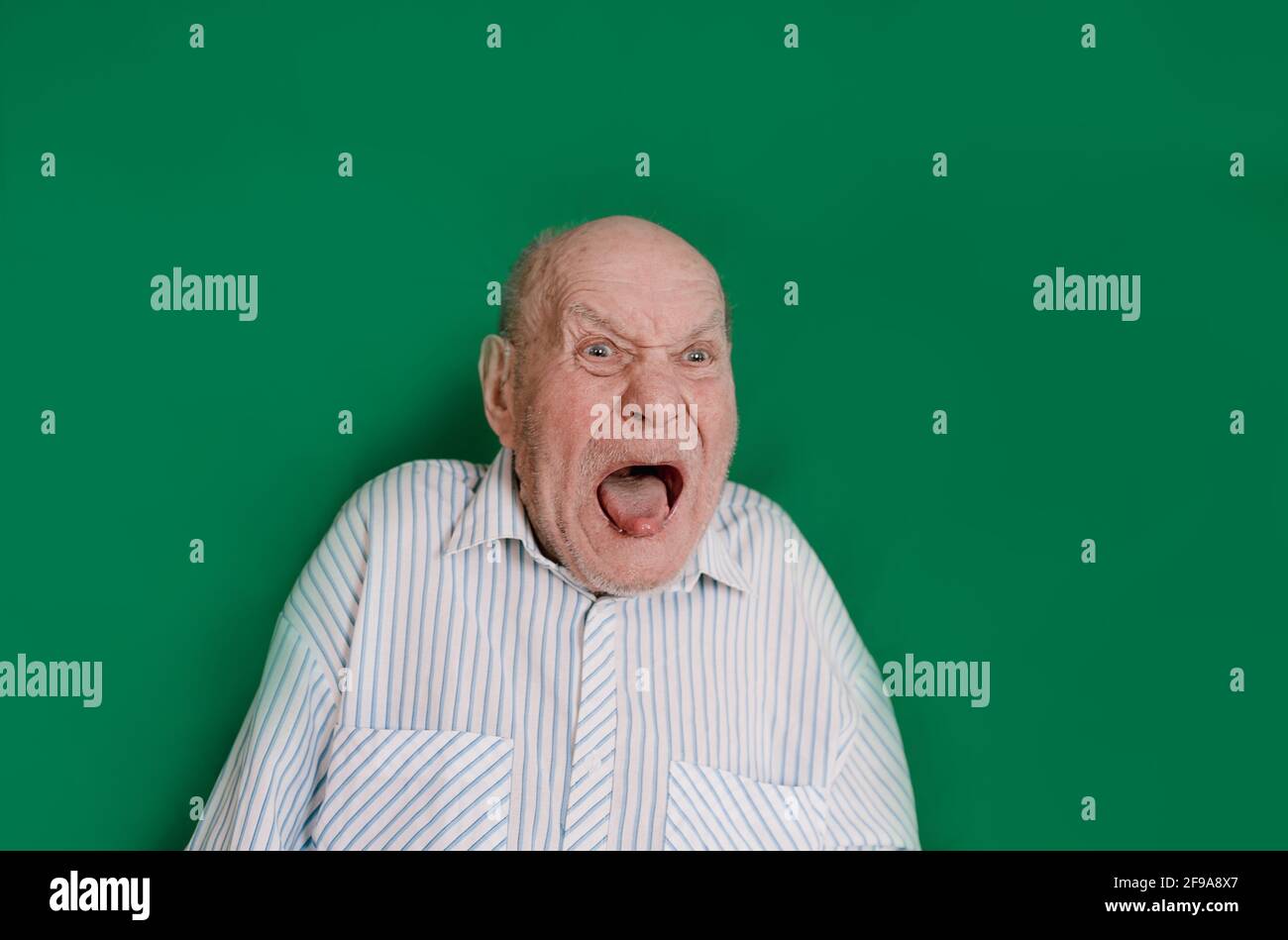 large portrait of a crazy old man on an isolated green background Stock ...