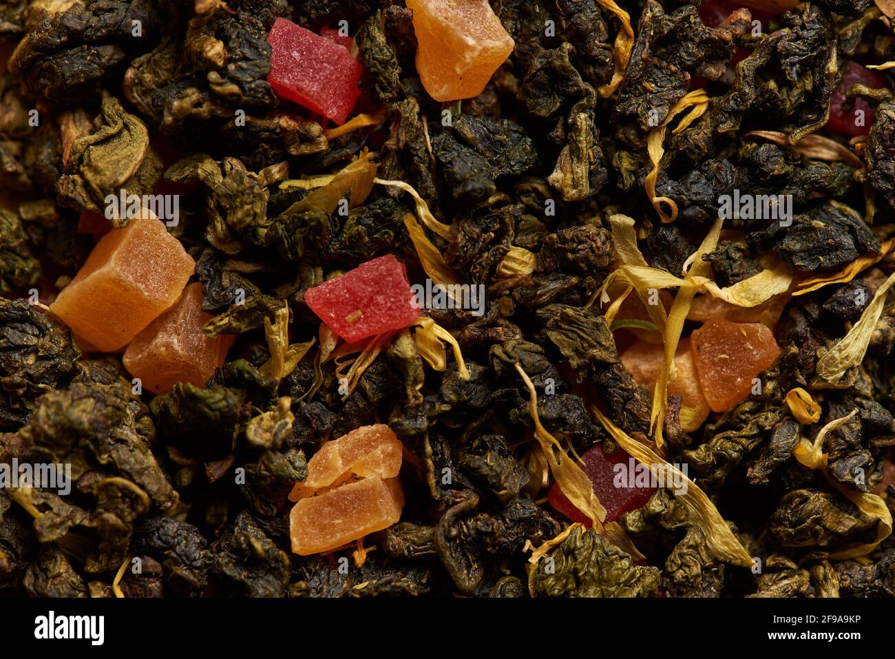Tea leaves texture with flower petals and berries as a background Stock ...