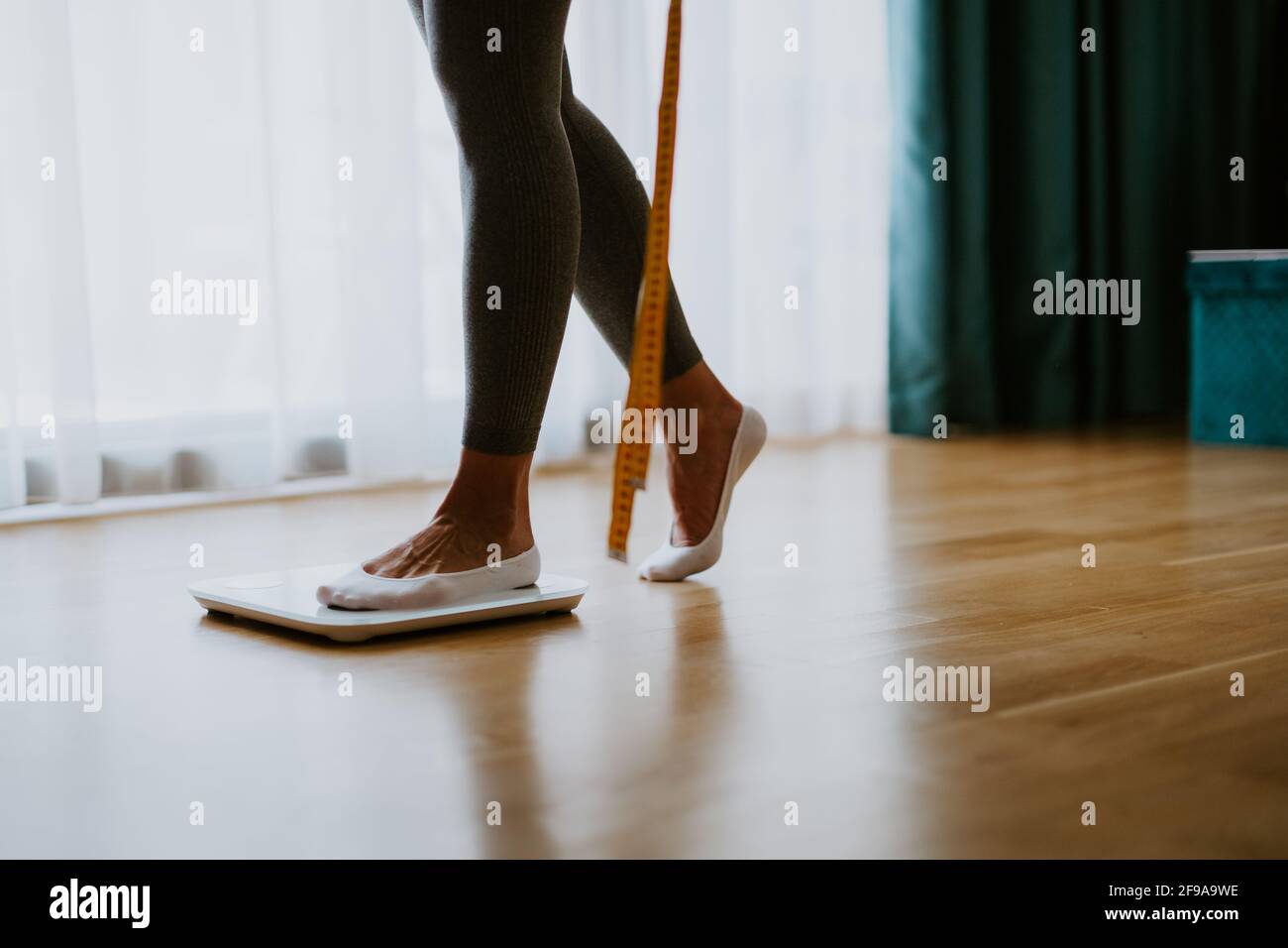 Woman Measuring Body Weight On Weighing Scale At Home Stock Photo - Alamy