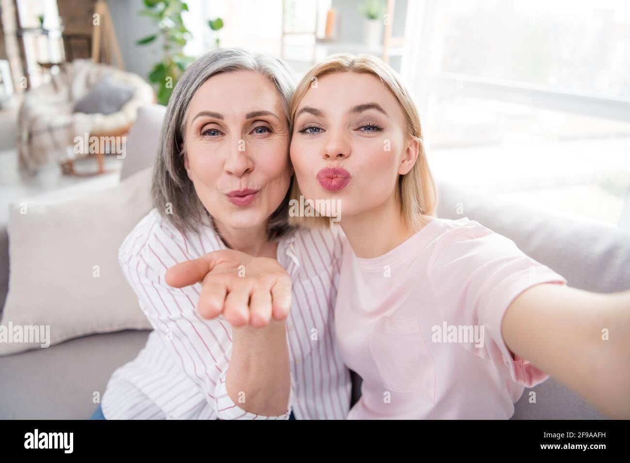 Self-portrait of two attractive elderly cheerful women sitting on cozy ...
