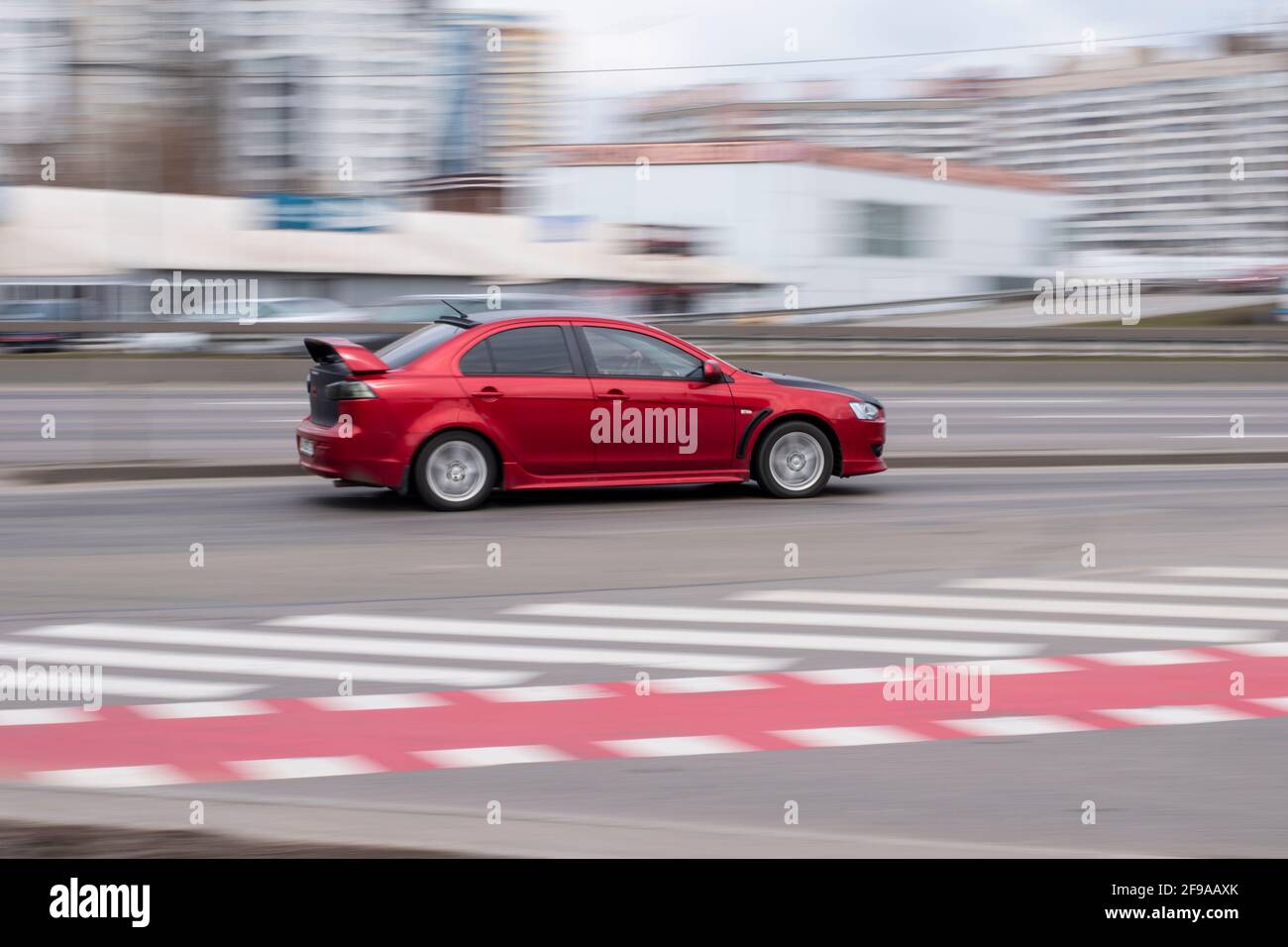 Ukraine, Kyiv - 18 March 2021: Red Mitsubishi Lancer car moving on the ...