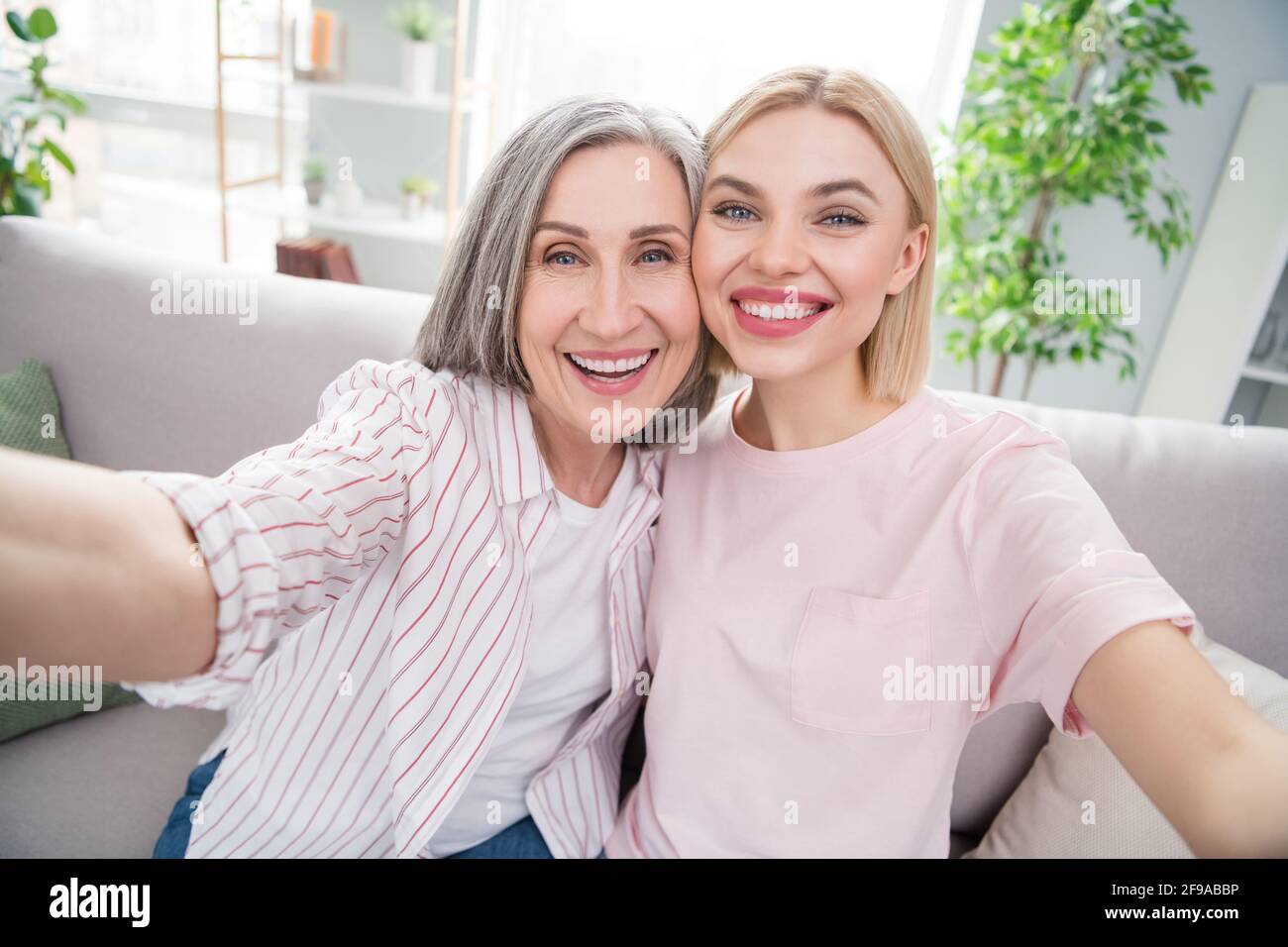 Self-portrait of two attractive cheerful elderly women sitting on cozy ...