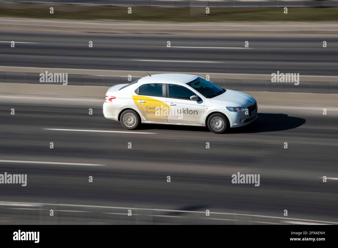Ukraine, Kyiv - 3 March 2021: White Taxi Uklon car moving on the street ...