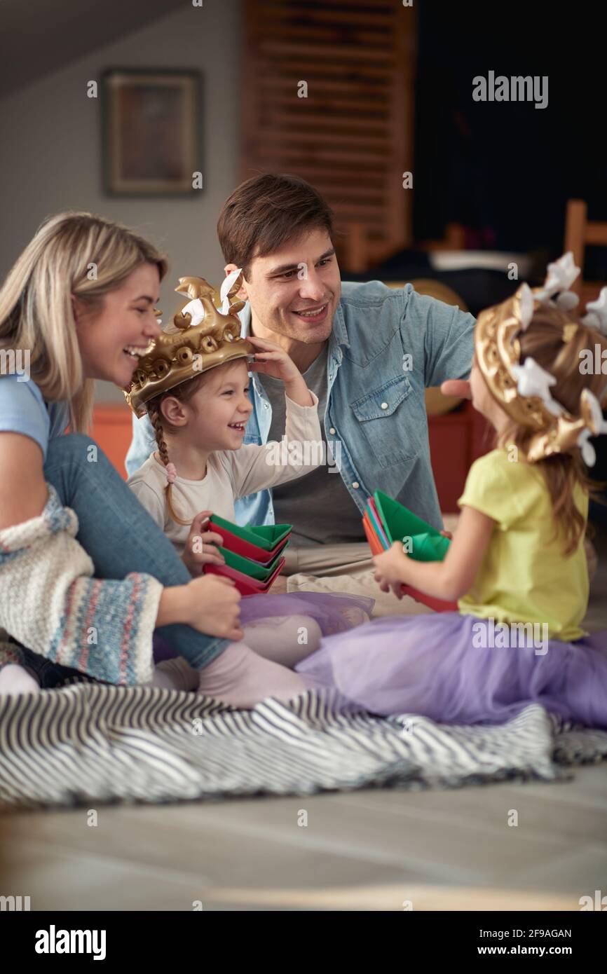 Young happy family sitting on the floor and playing in a relaxed ...