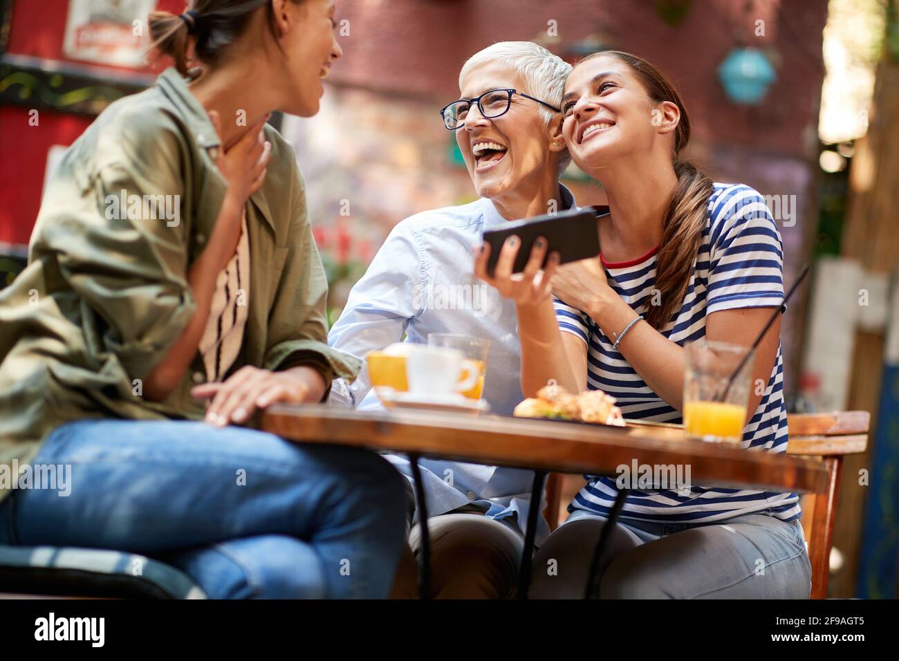 A group of female friends of different generations are laughing at ...