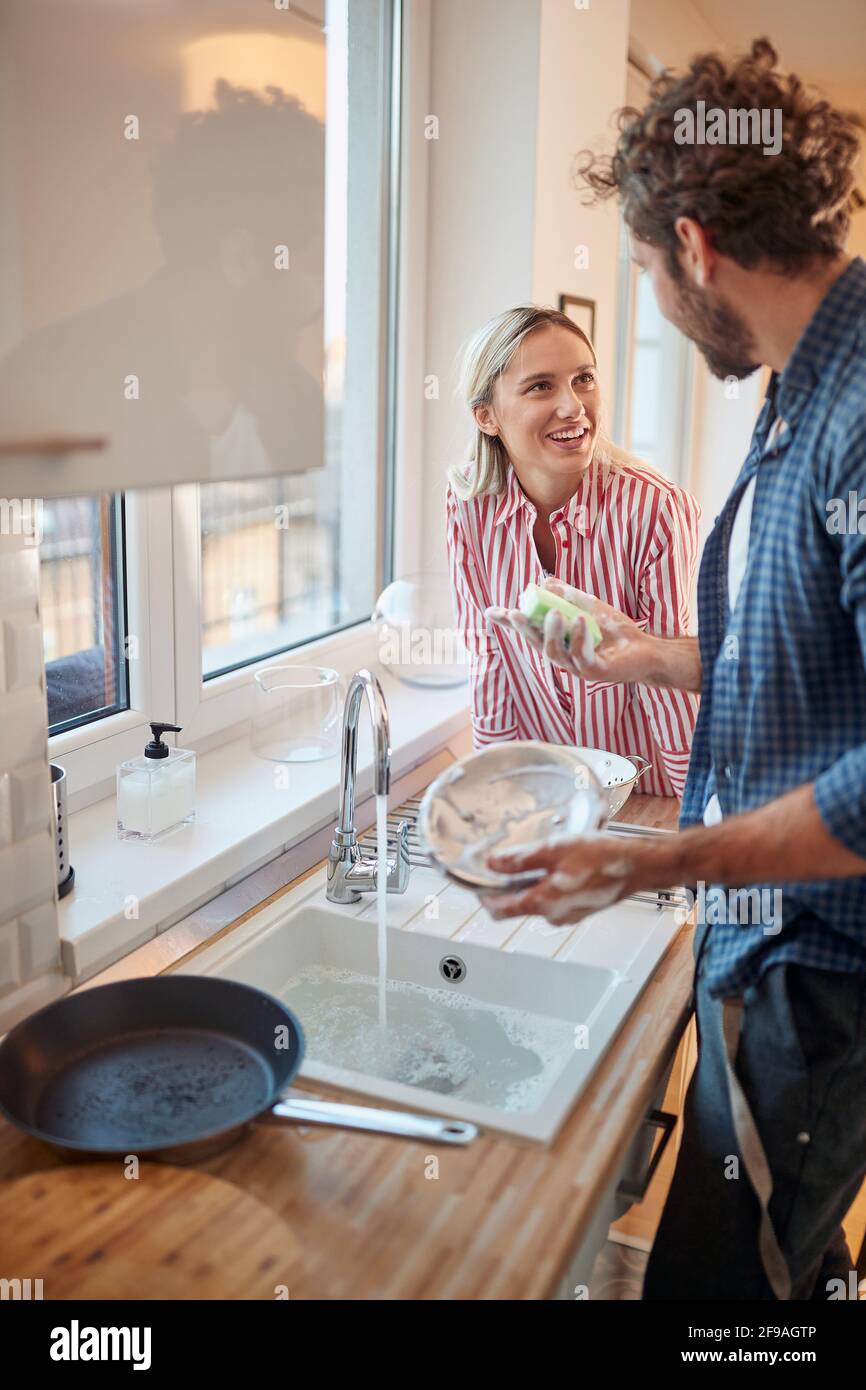 young caucasian adult couple having fun while washing dishes Stock ...