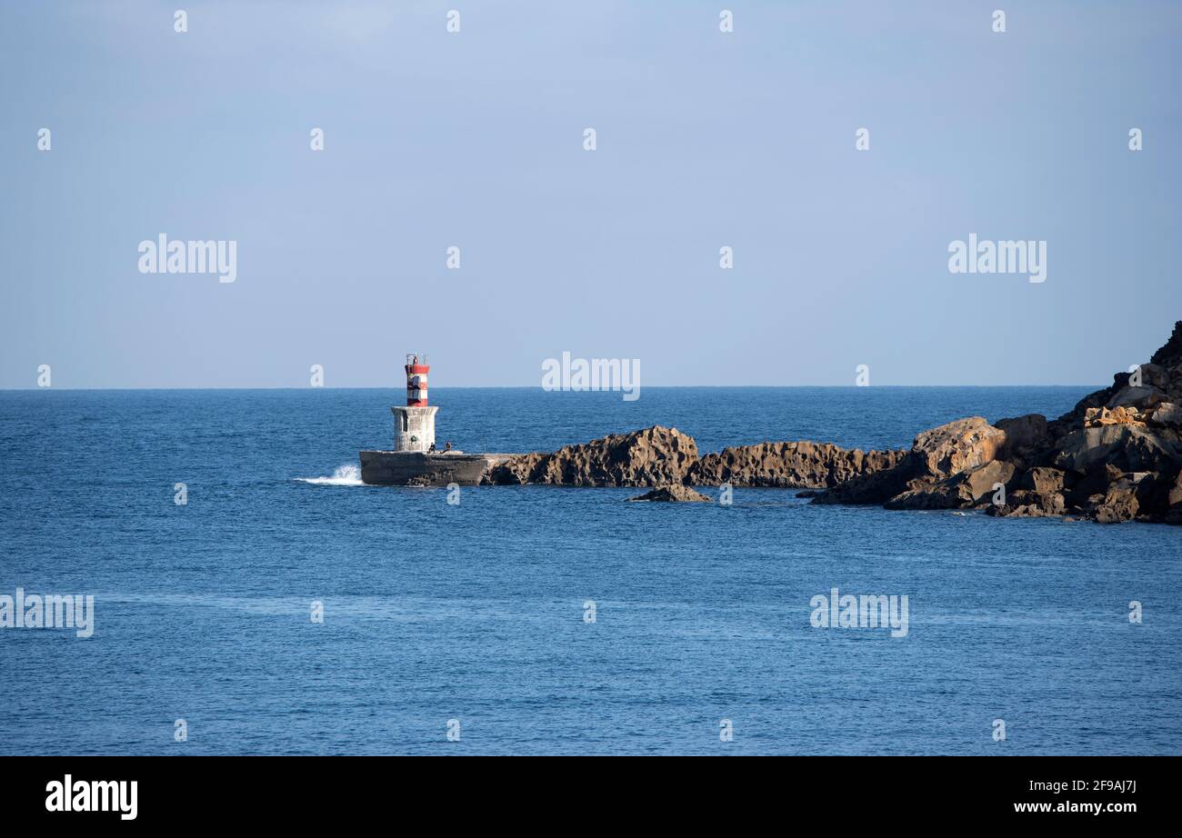 Lighthouse marking the entrance to a harbor Stock Photo - Alamy