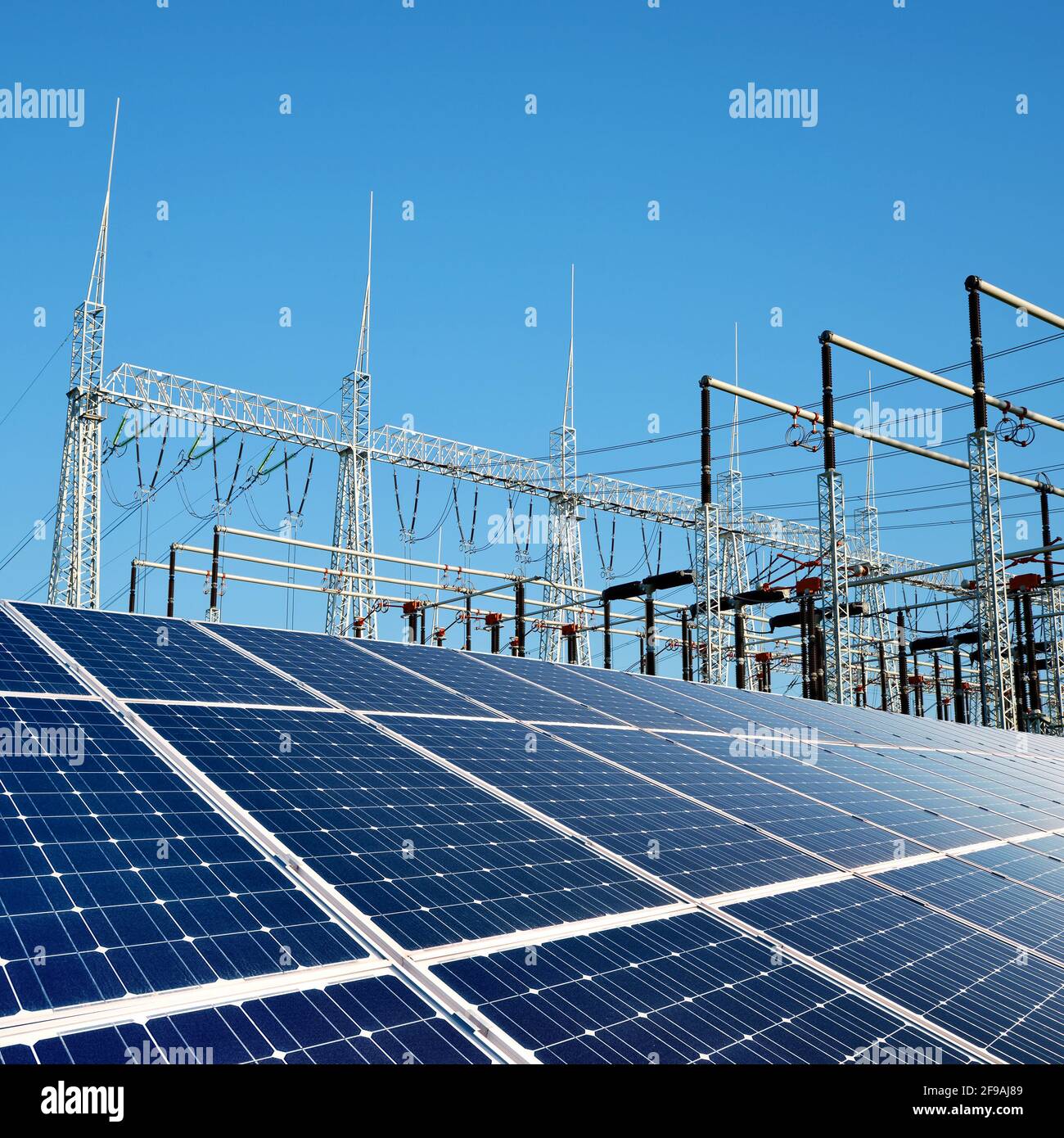 Solar energy panels in the background high voltage power substation ...