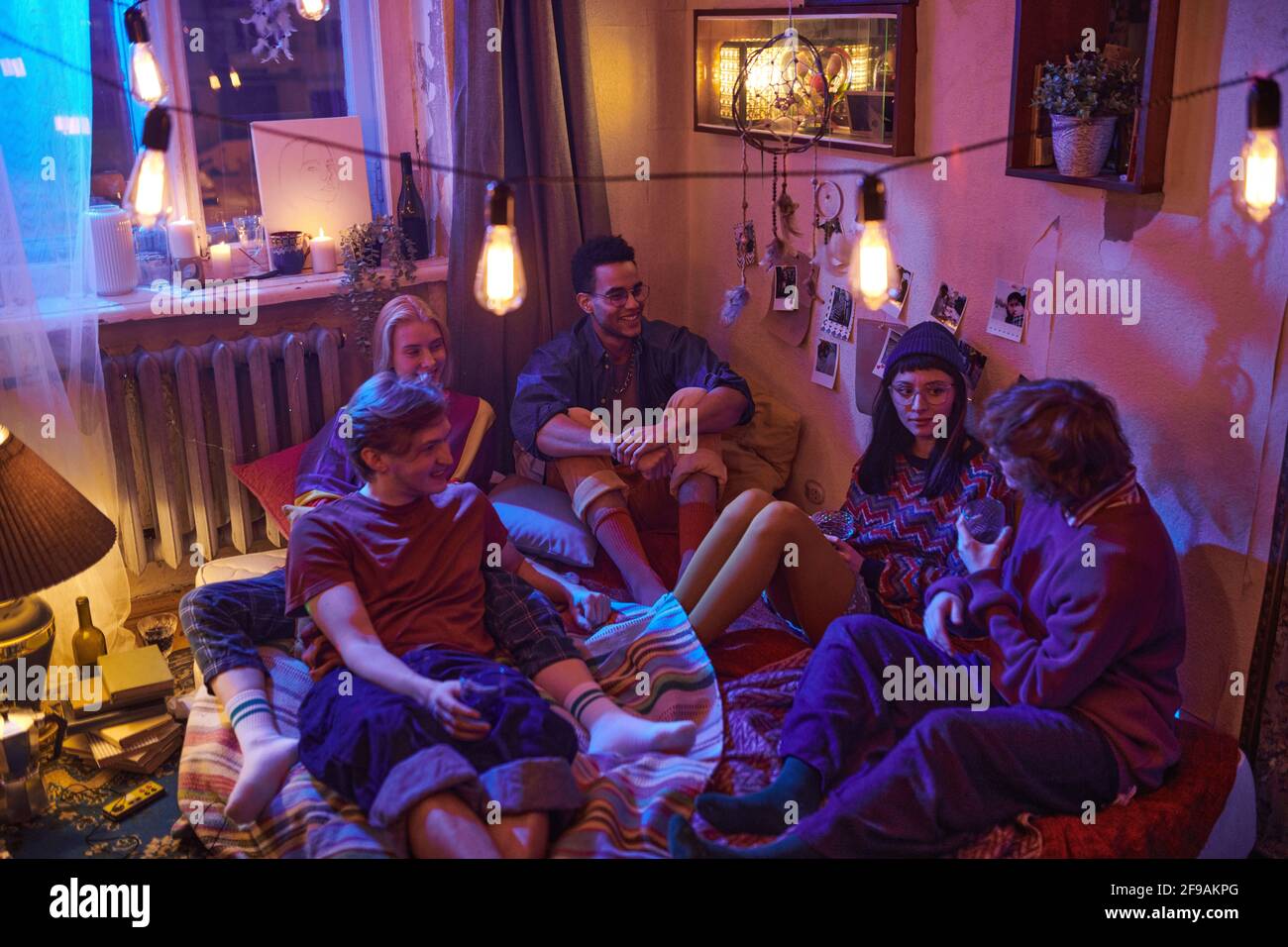 Group of young people sitting on the floor talking and having fun ...