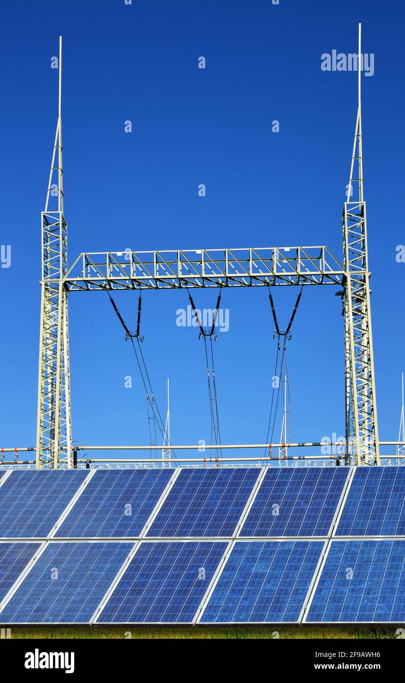 Solar energy panels in the background high voltage power substation ...