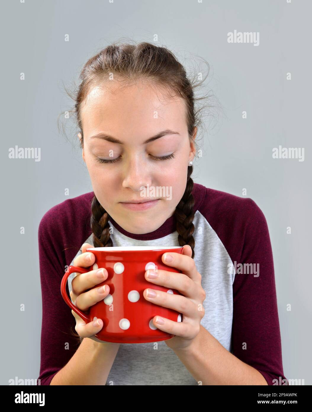 Beautiful young girl smelling a cup of drink Stock Photo - Alamy