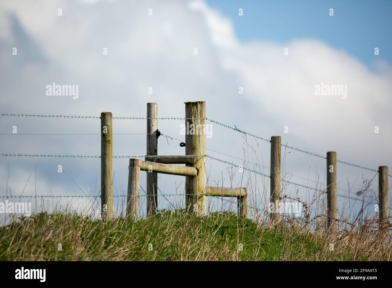 A Wooden turnstile in the english countryside with blue sky and fluffy ...
