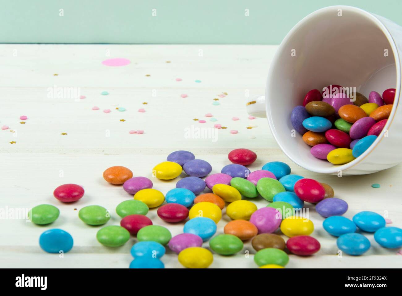 Colored candy bonbons scattered on white wooden board background Studio ...