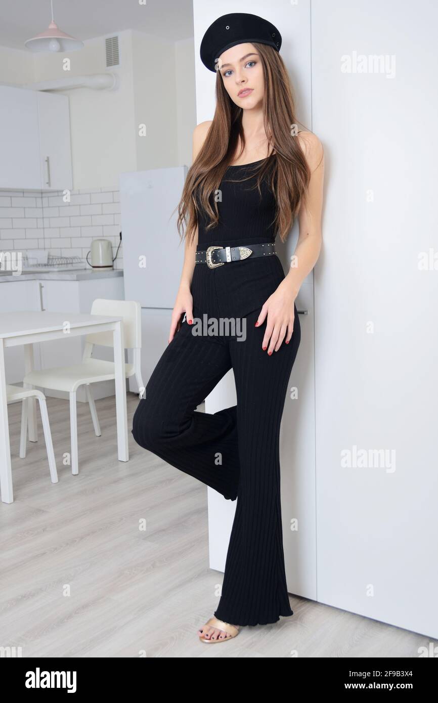 Young woman with black armless top, black flared pants and black beret ...