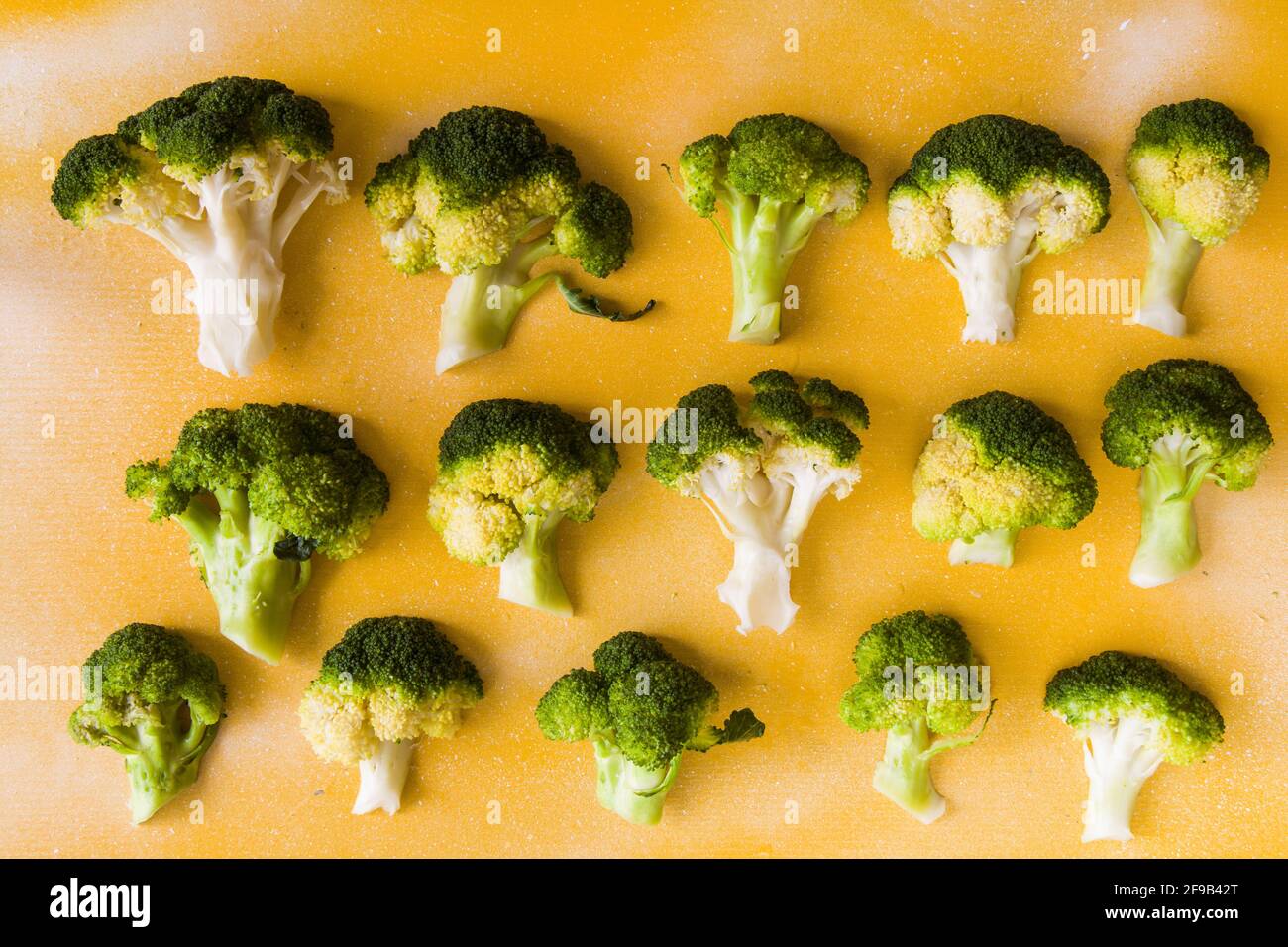Top view of bunch of broccoli on a yellow background Stock Photo - Alamy