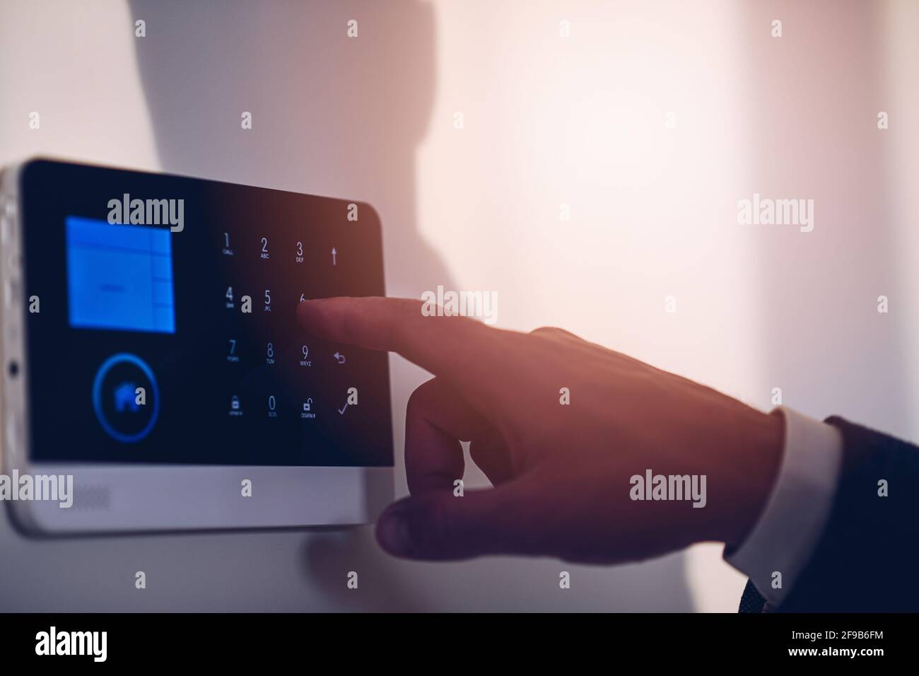 Man's hand enters authorization code pin on home alarm keypad Stock ...