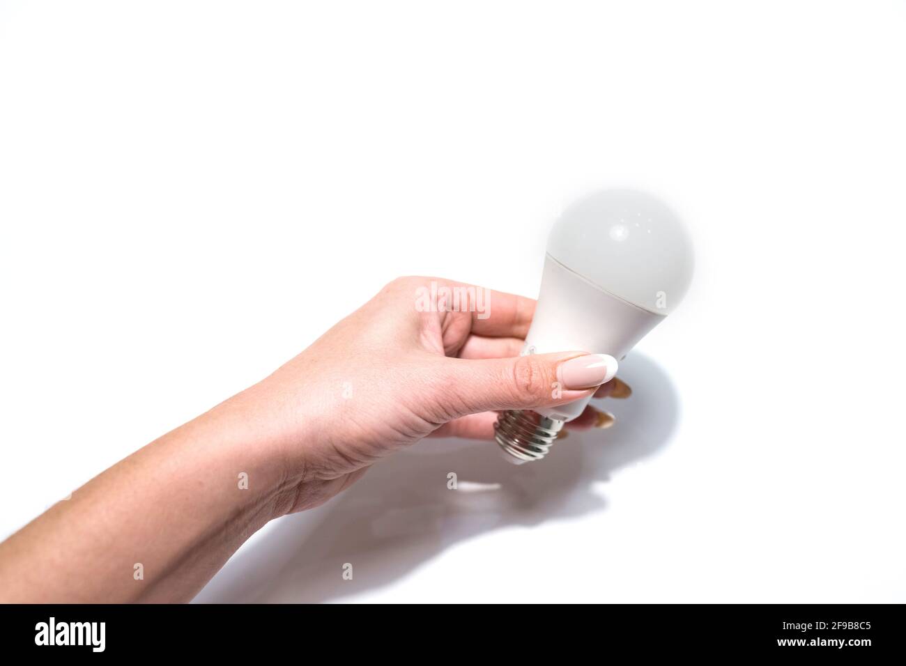 Electric diode light bulb in hand, isolated on white studio background ...