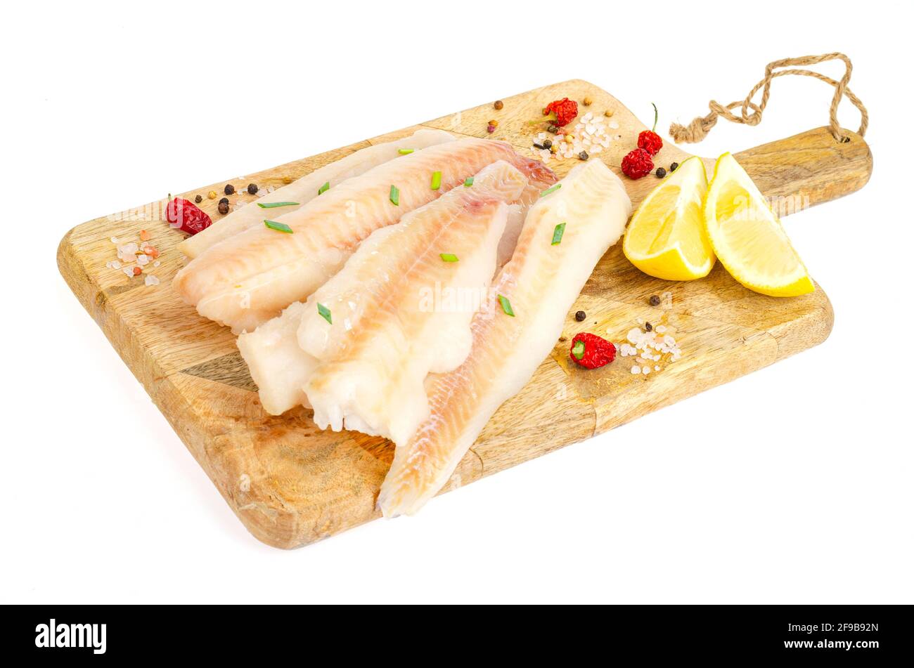 Raw pollock fillet on kitchen cutting wooden board. Studio Photo Stock ...