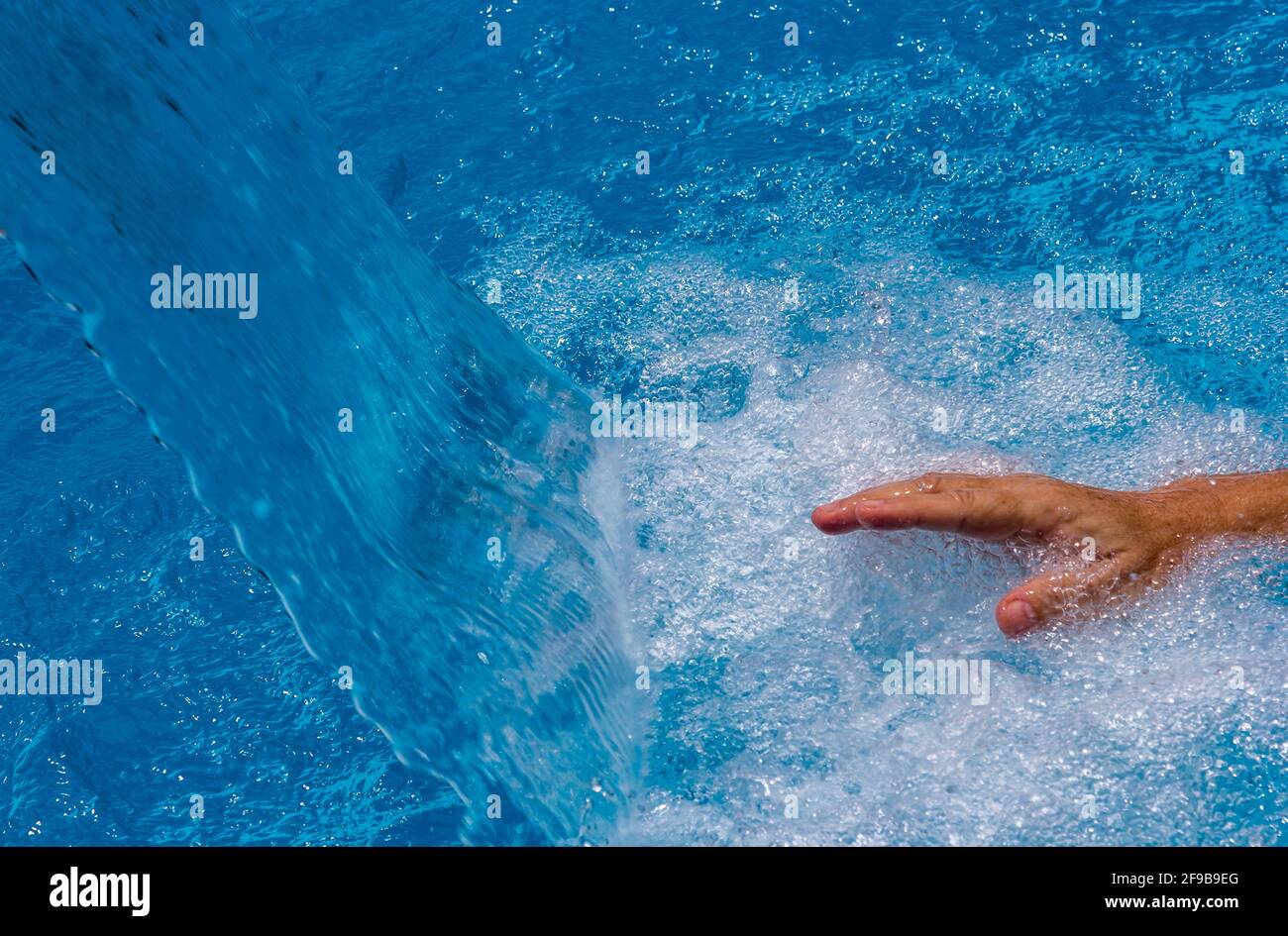 Hand playing with the pool water bubbles Stock Photo - Alamy