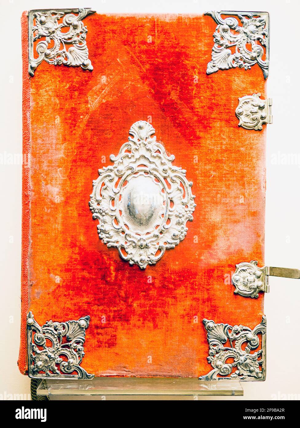 Top view of an old medieval book with orange covering and metallic ...