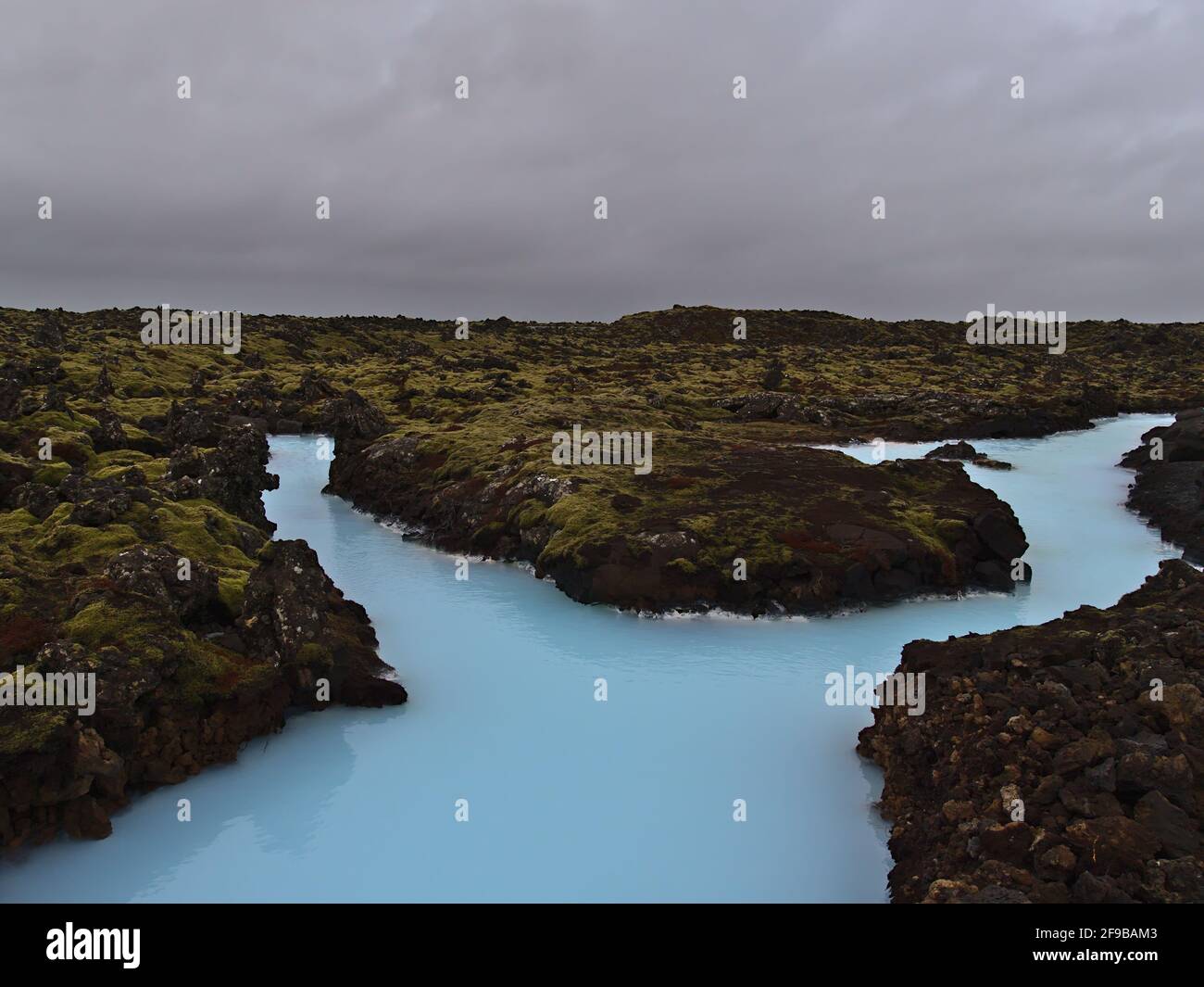 Pool with blue colored thermal water in a moss covered lava field near ...