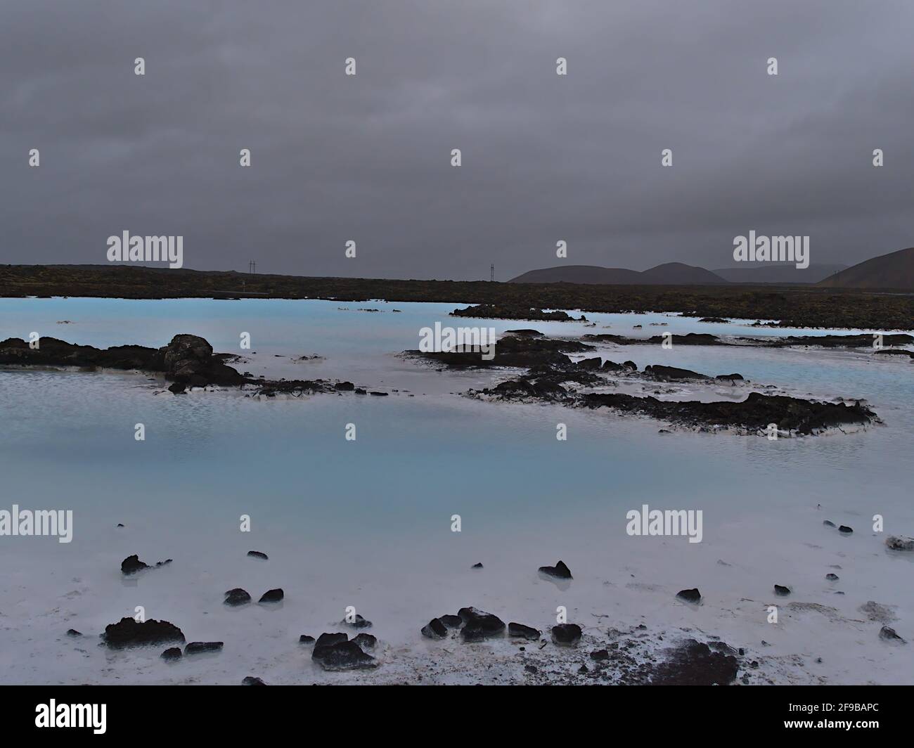 Pools with blue colored thermal water and white deposits surrounded by ...