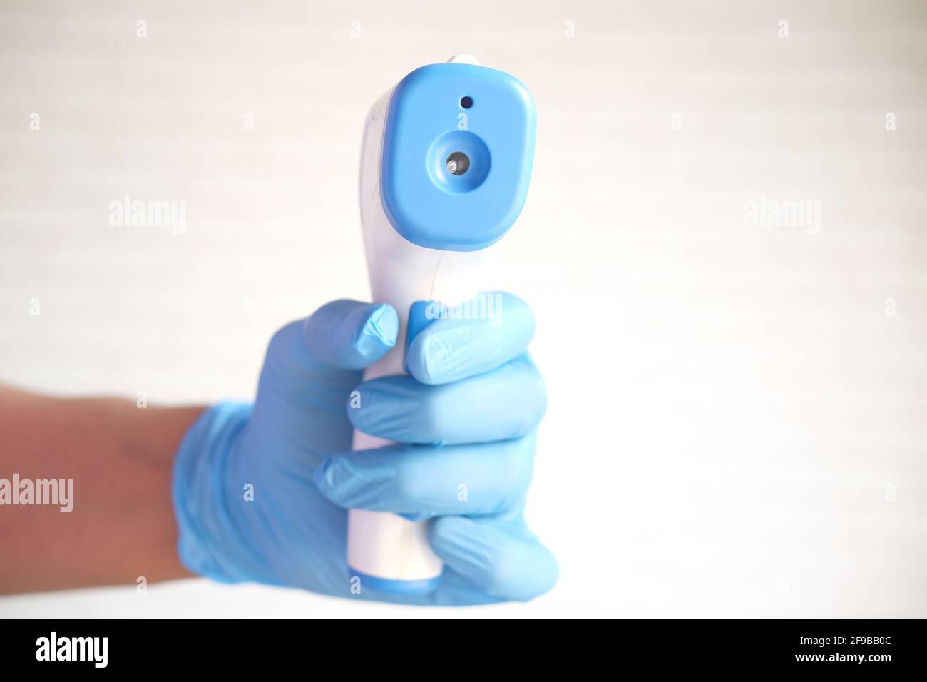Hand holding infrared thermometer to measuring temperature Stock Photo ...