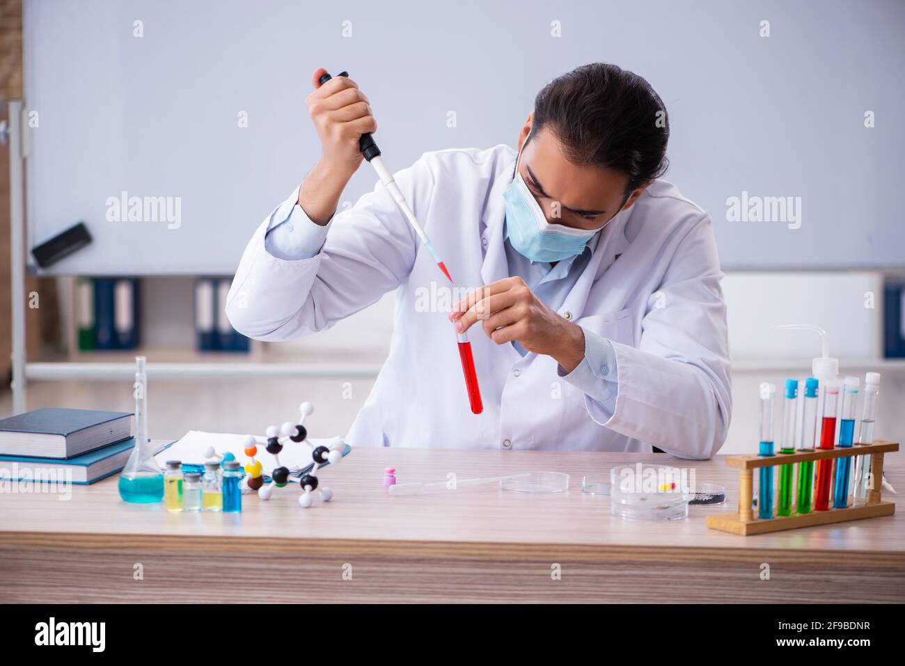 Young chemist teacher sitting in the classroom Stock Photo - Alamy