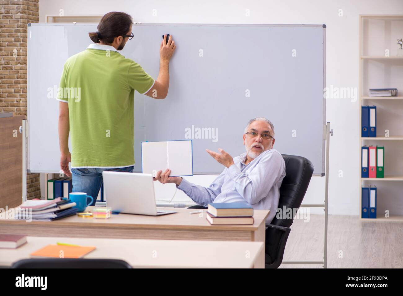 Aged male teacher and young male student in the classroom Stock Photo ...