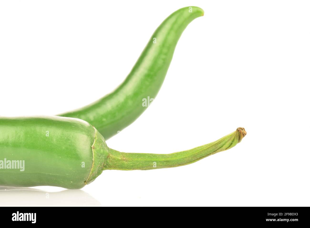 Two dark green organic, natural, spicy, hot pepper pods on a white ...